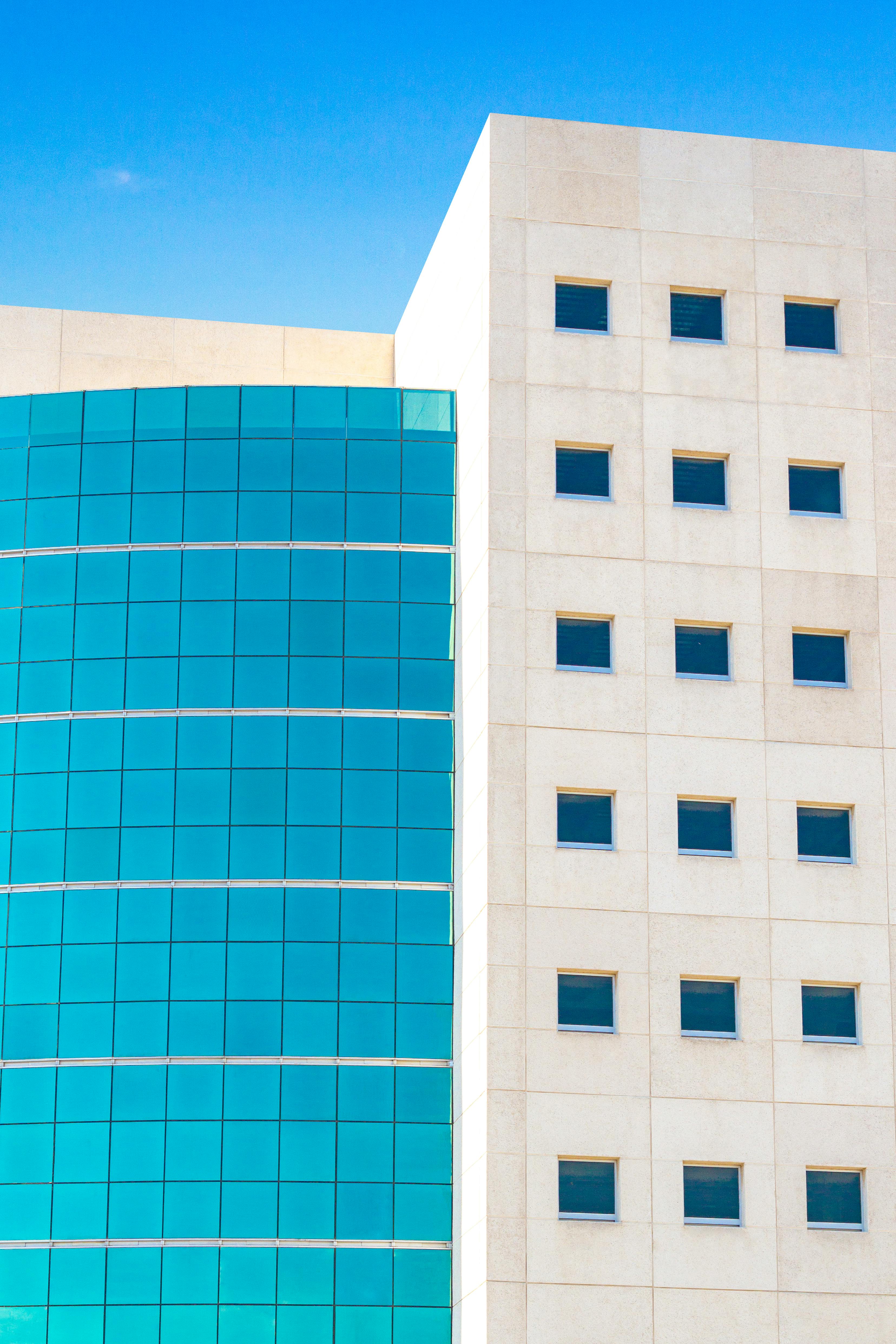 Blue and White Concrete Building with Glass Windows · Free Stock Photo