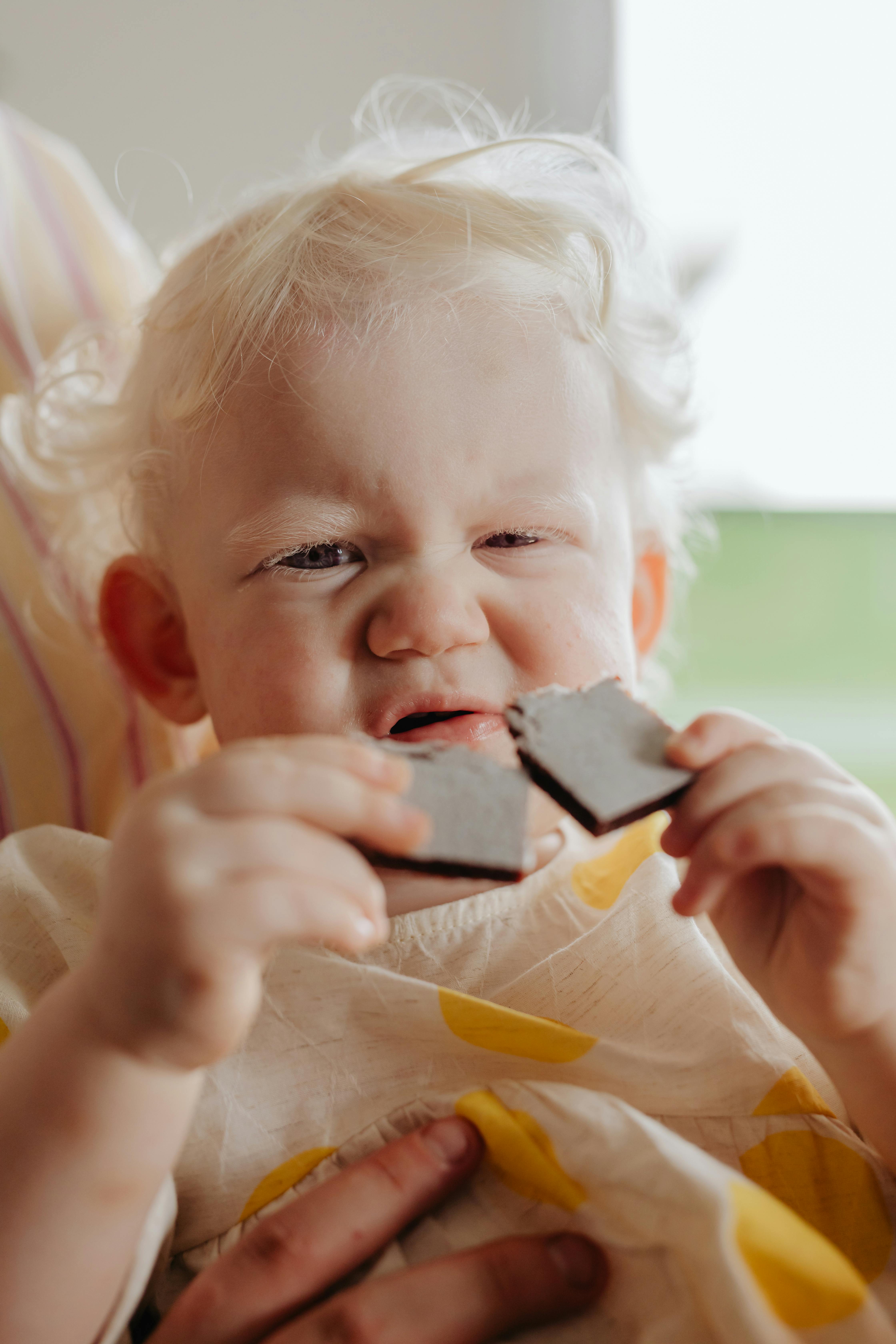 Close-Up Shot of a Cute Baby Eating · Free Stock Photo