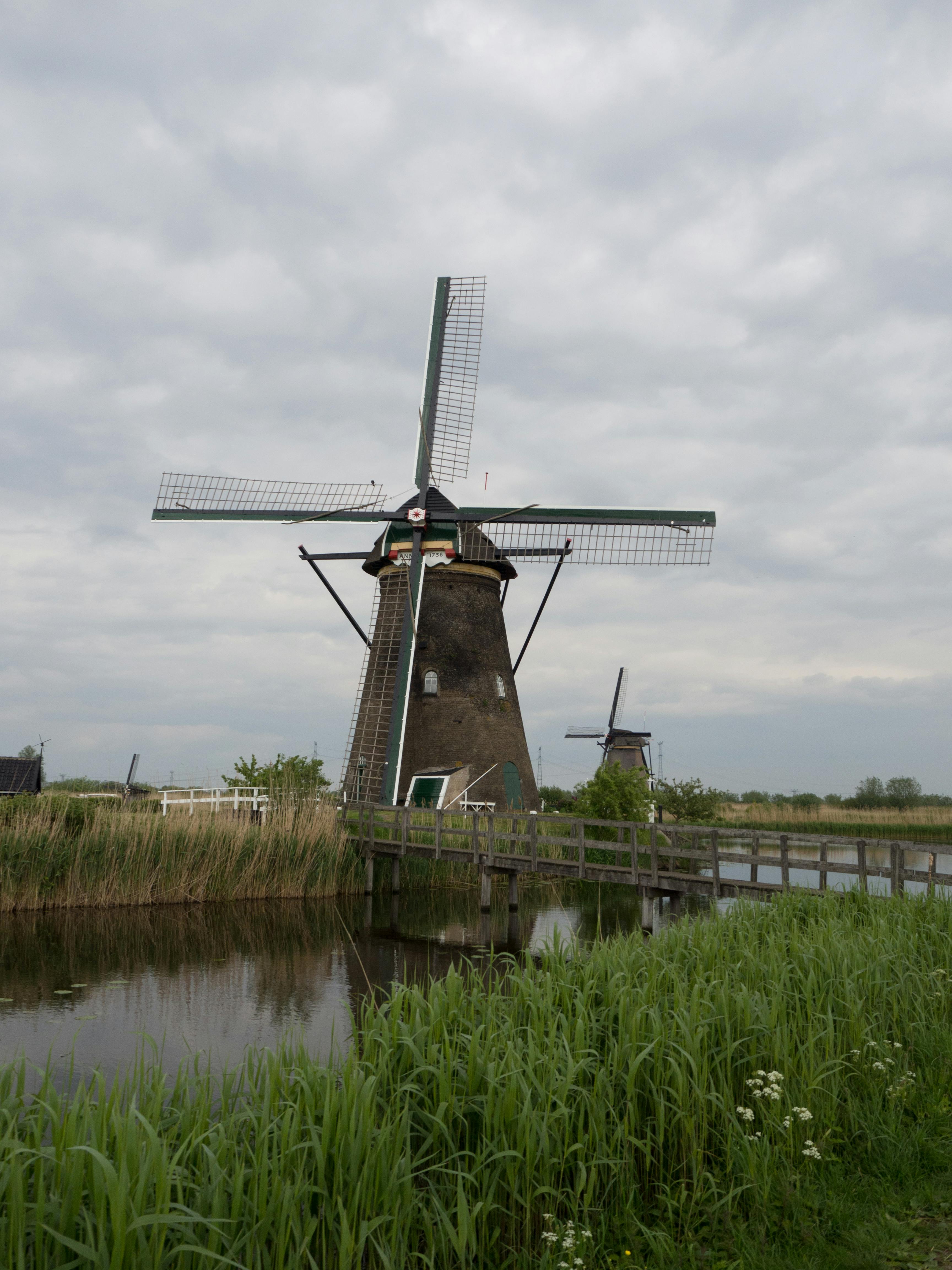 Brown and Gray Windmill Beside Green Tree Under Blue Cloudy Sky during ...
