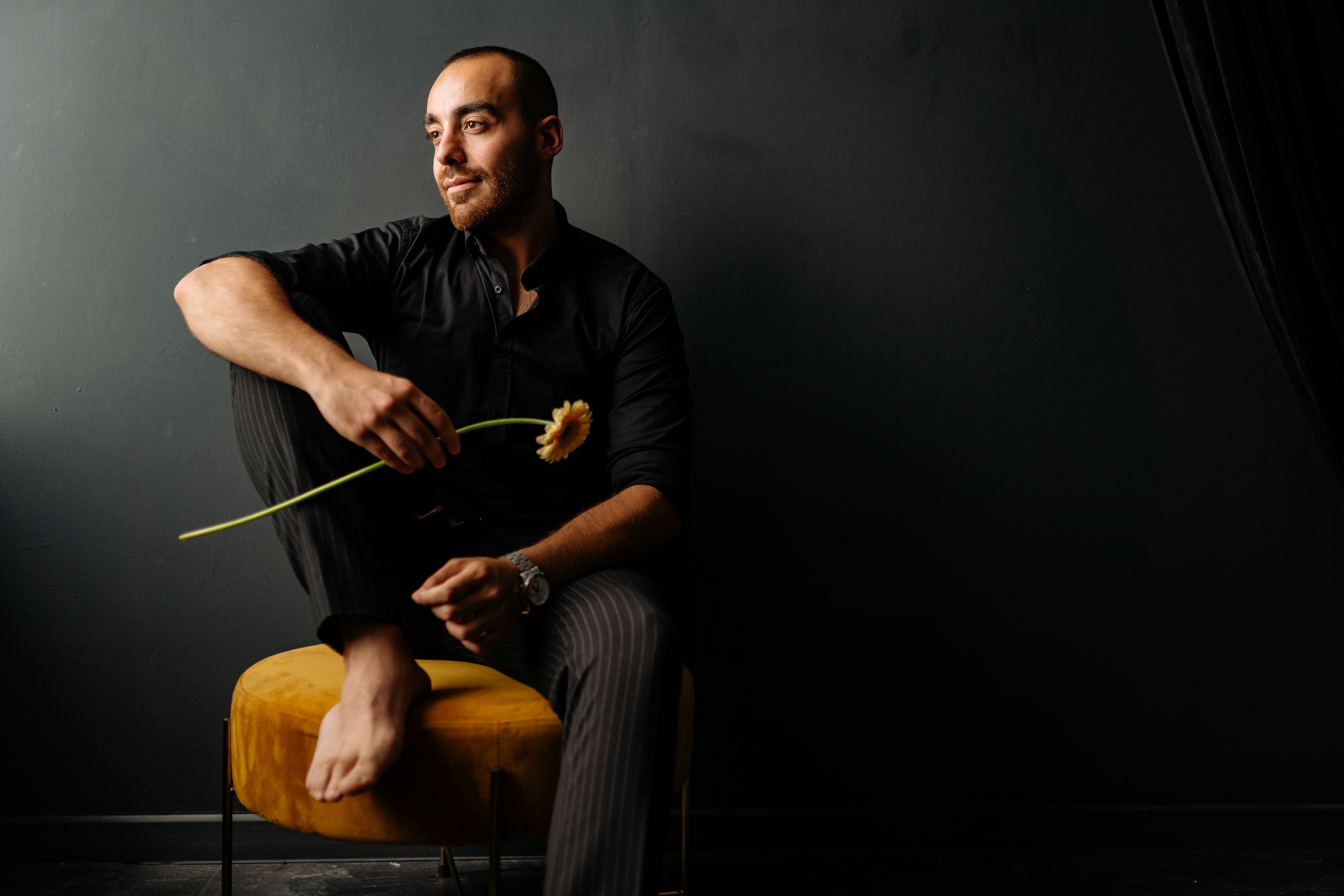 Man Biting a Flower While Sitting on a Chair · Free Stock Photo
