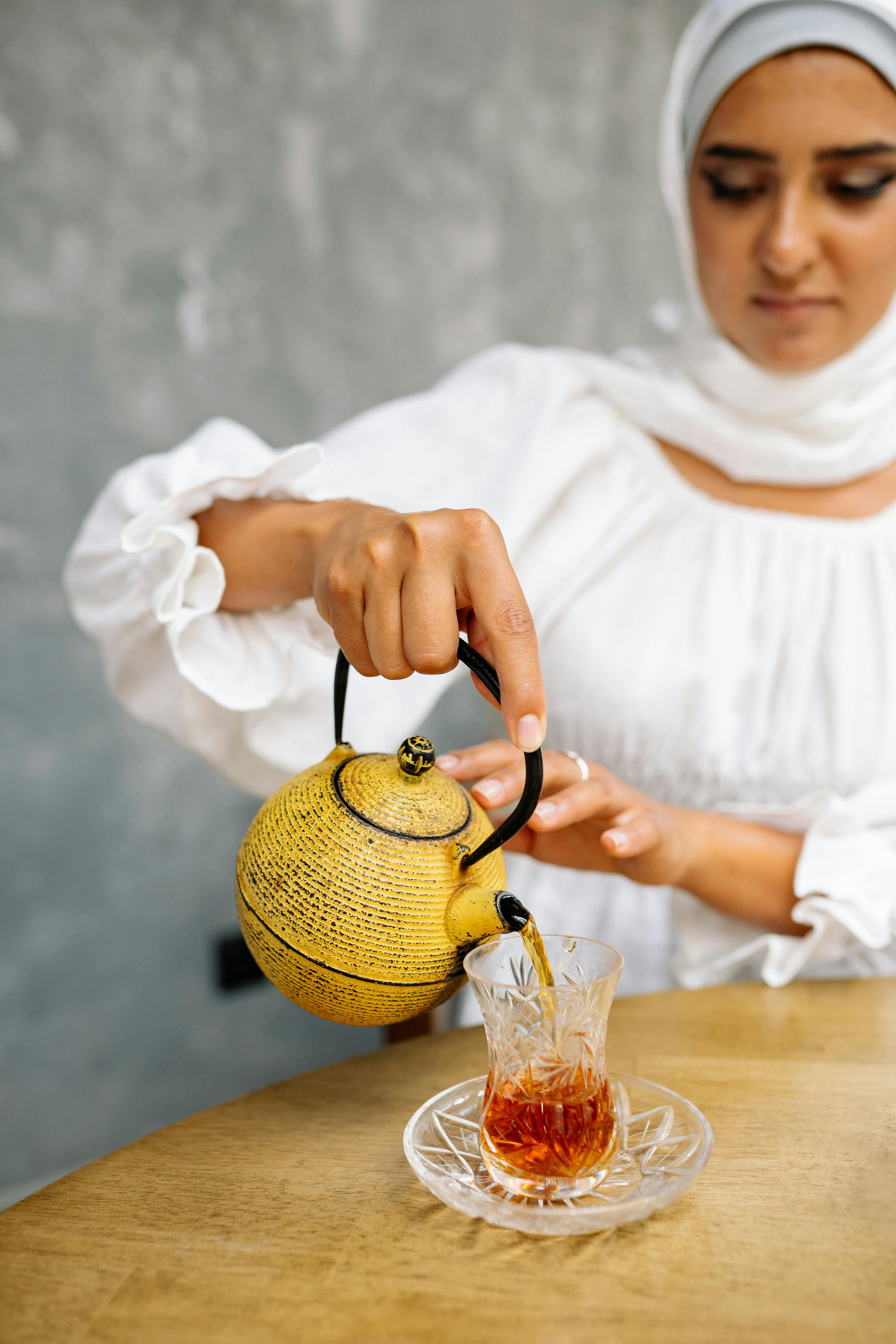 A Woman Pouring a Tea in a Glass · Free Stock Photo