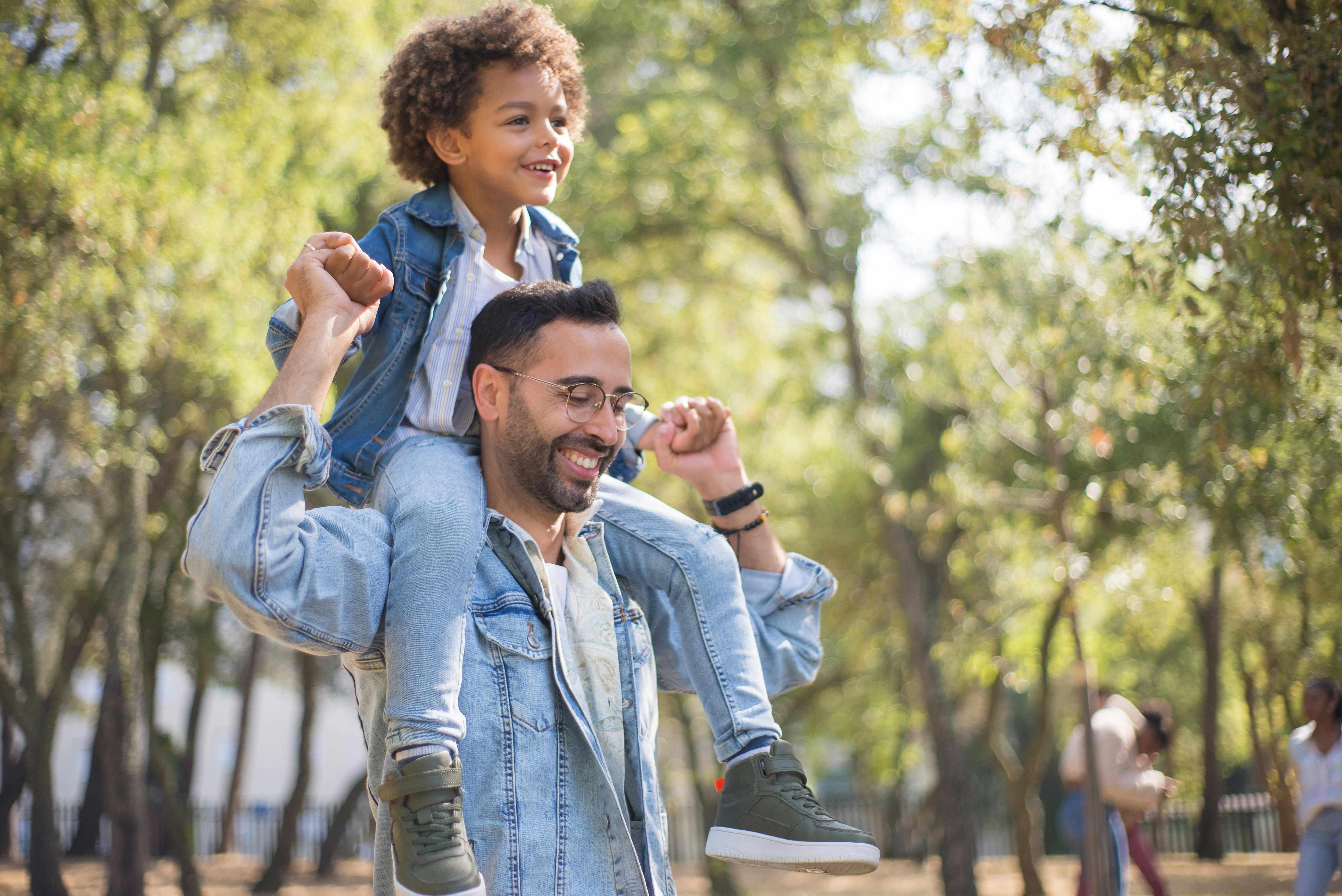Father Carrying His Son on His Shoulders · Free Stock Photo