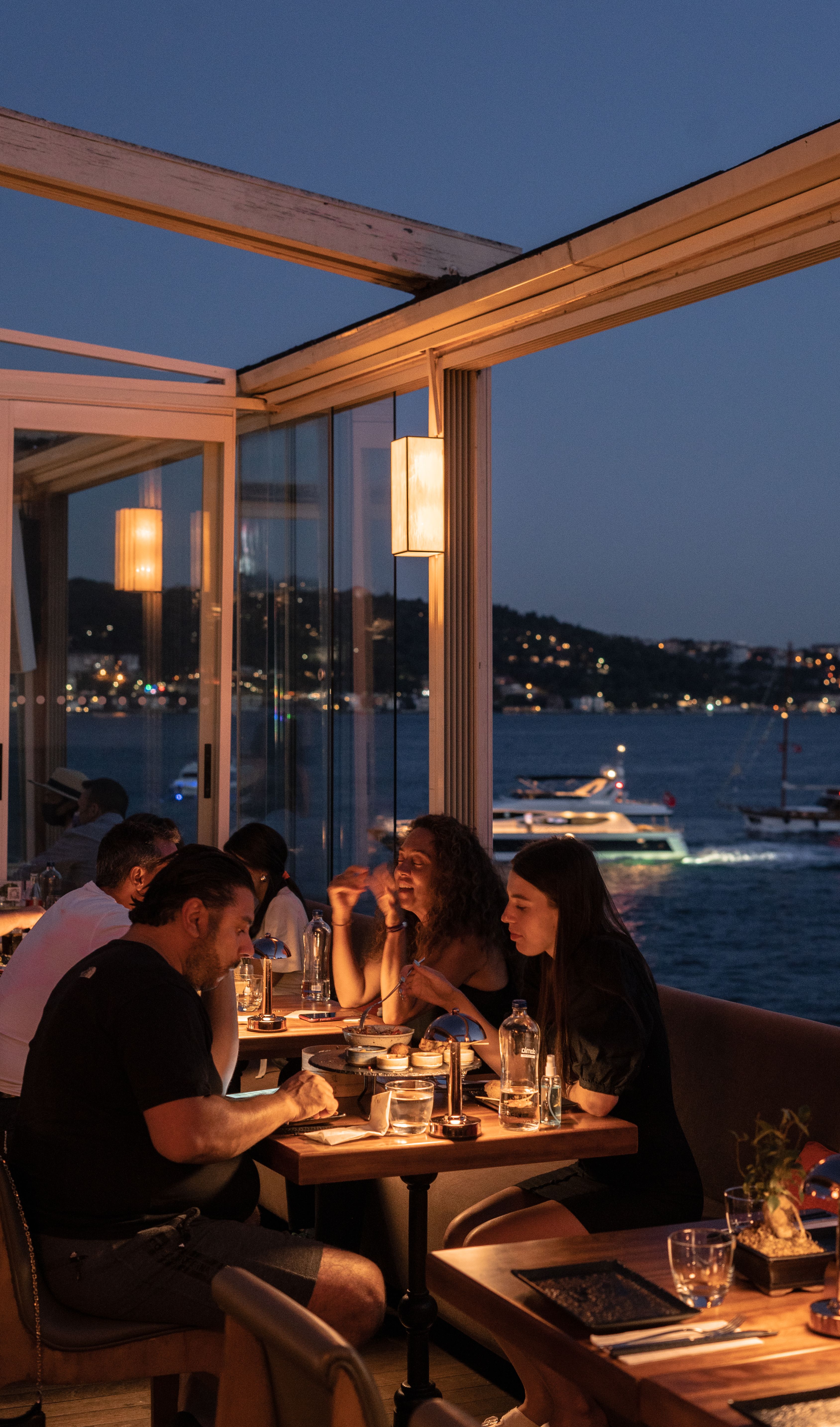 People Eating in a Restaurant Near Body of Water · Free Stock Photo