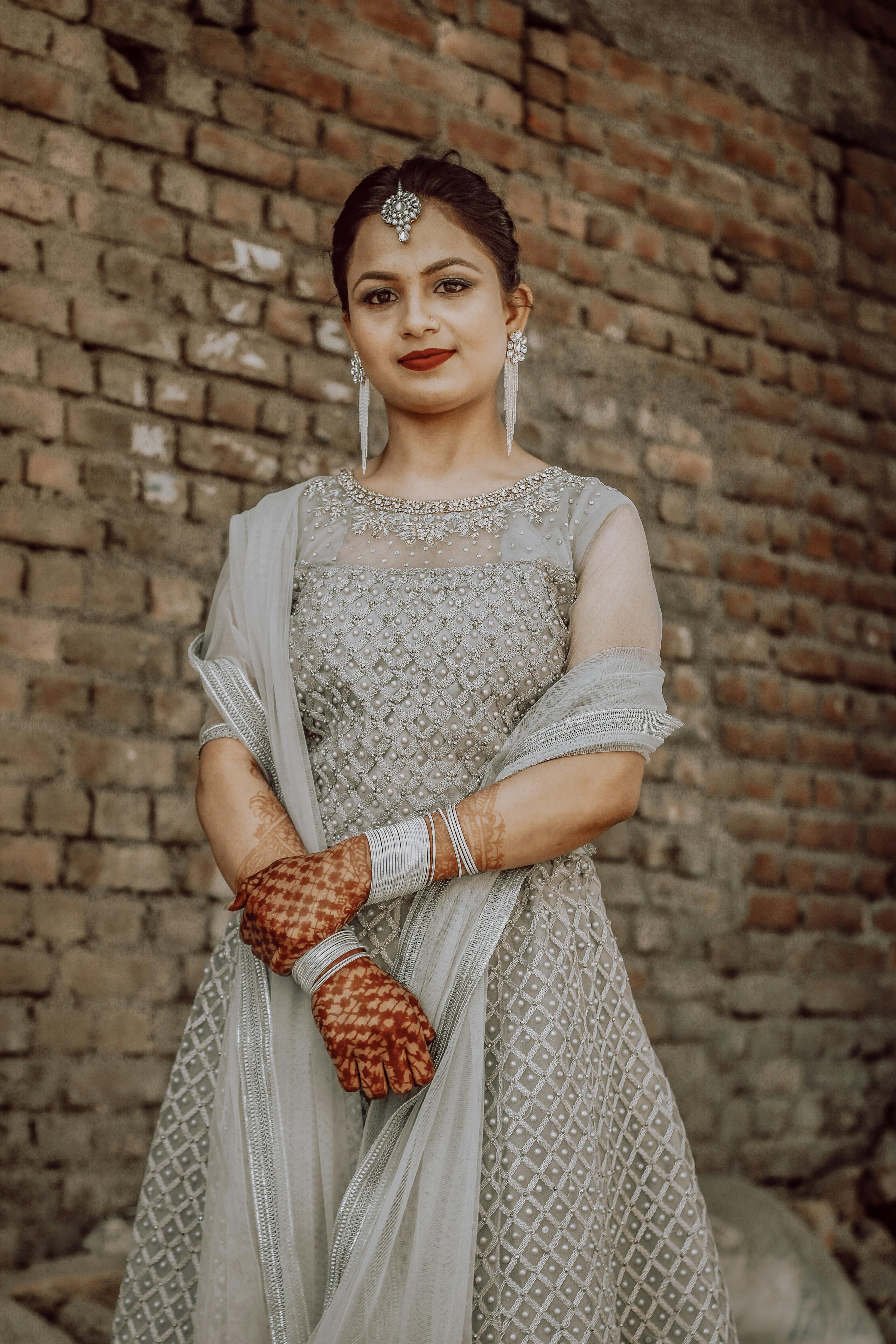 Woman in White Lace Dress Standing Beside Brown Brick Wall · Free Stock ...