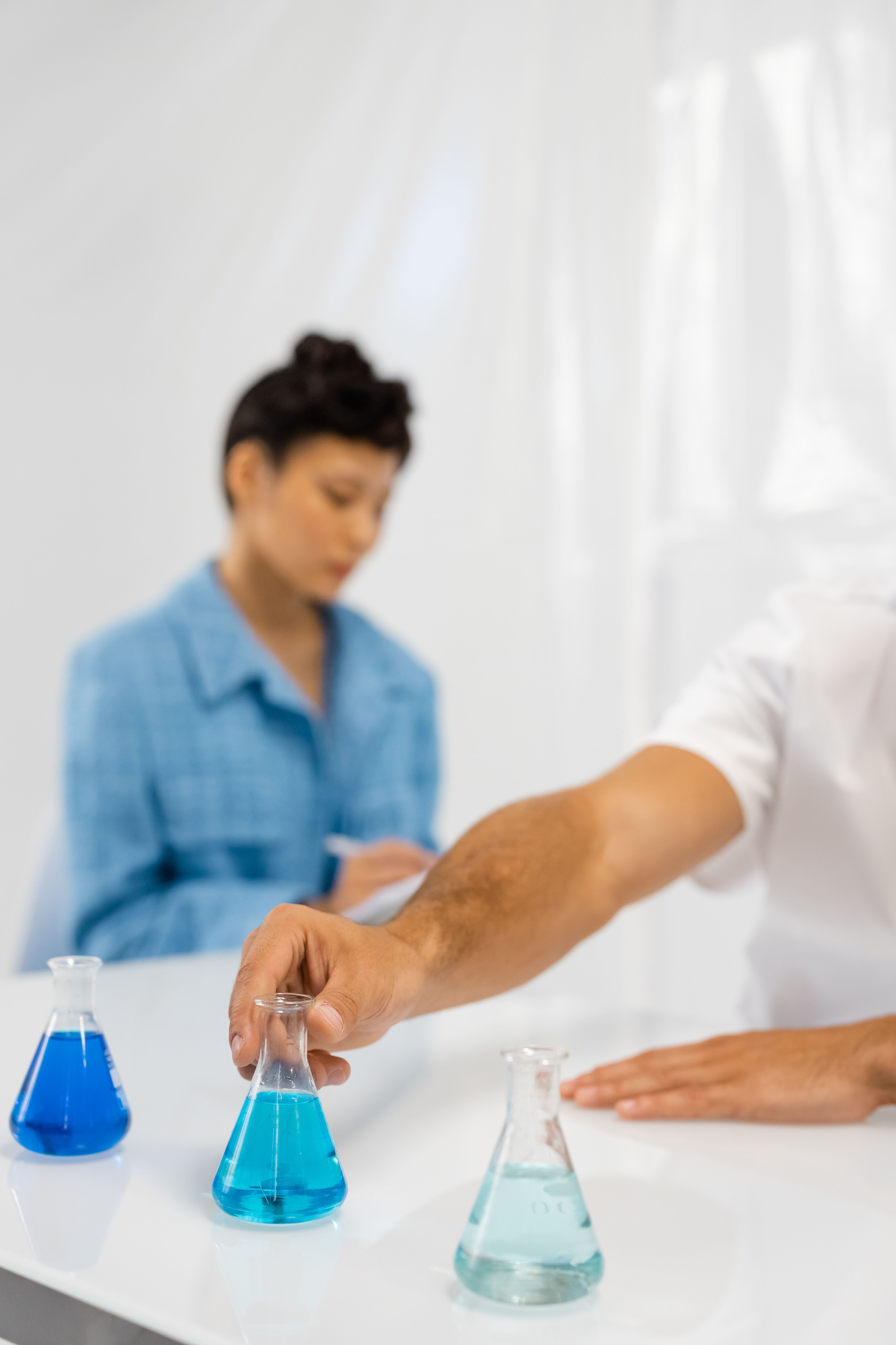 A Person Pouring Liquid on the Flask · Free Stock Photo