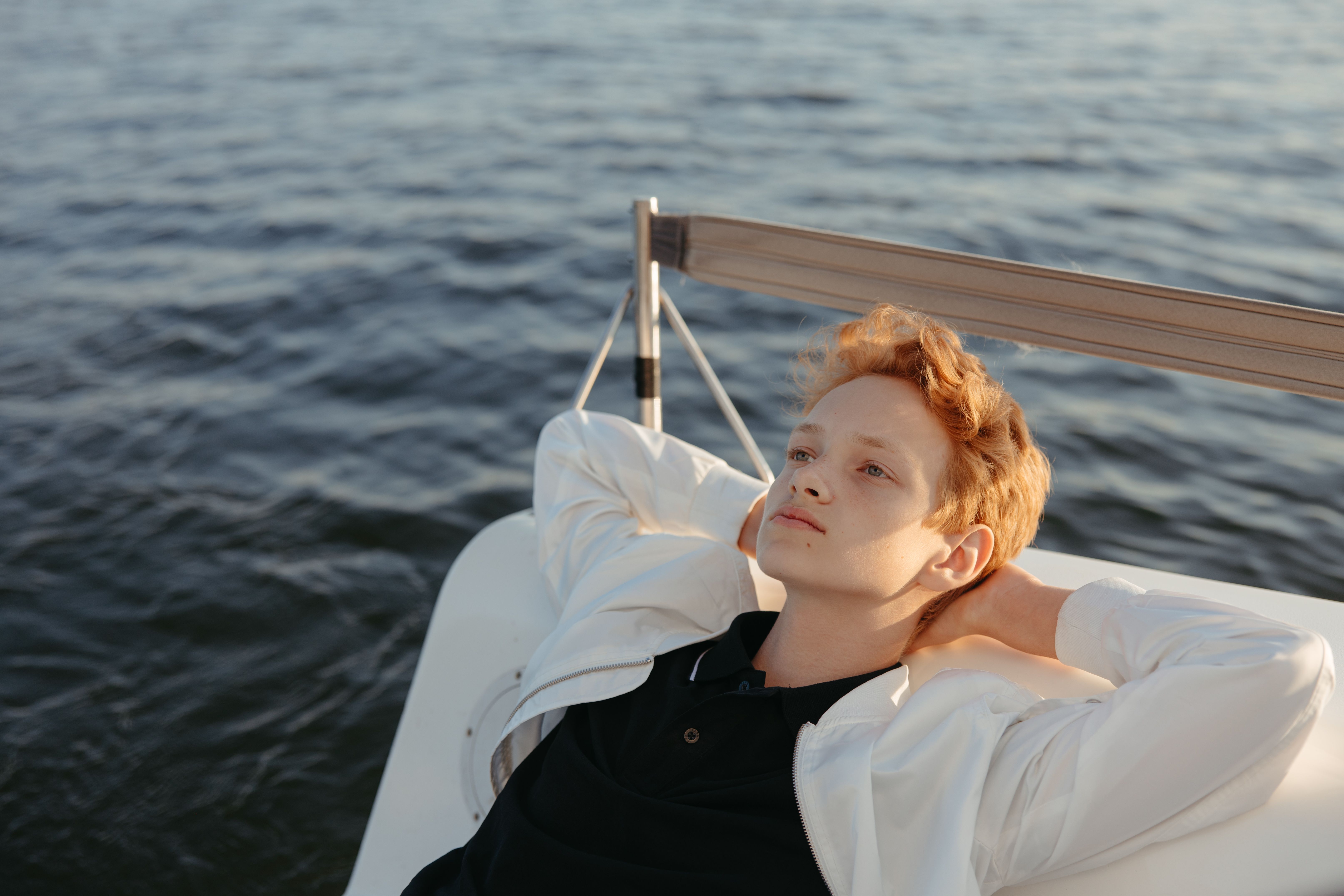 Teenage Boy Relaxing on a Boat · Free Stock Photo