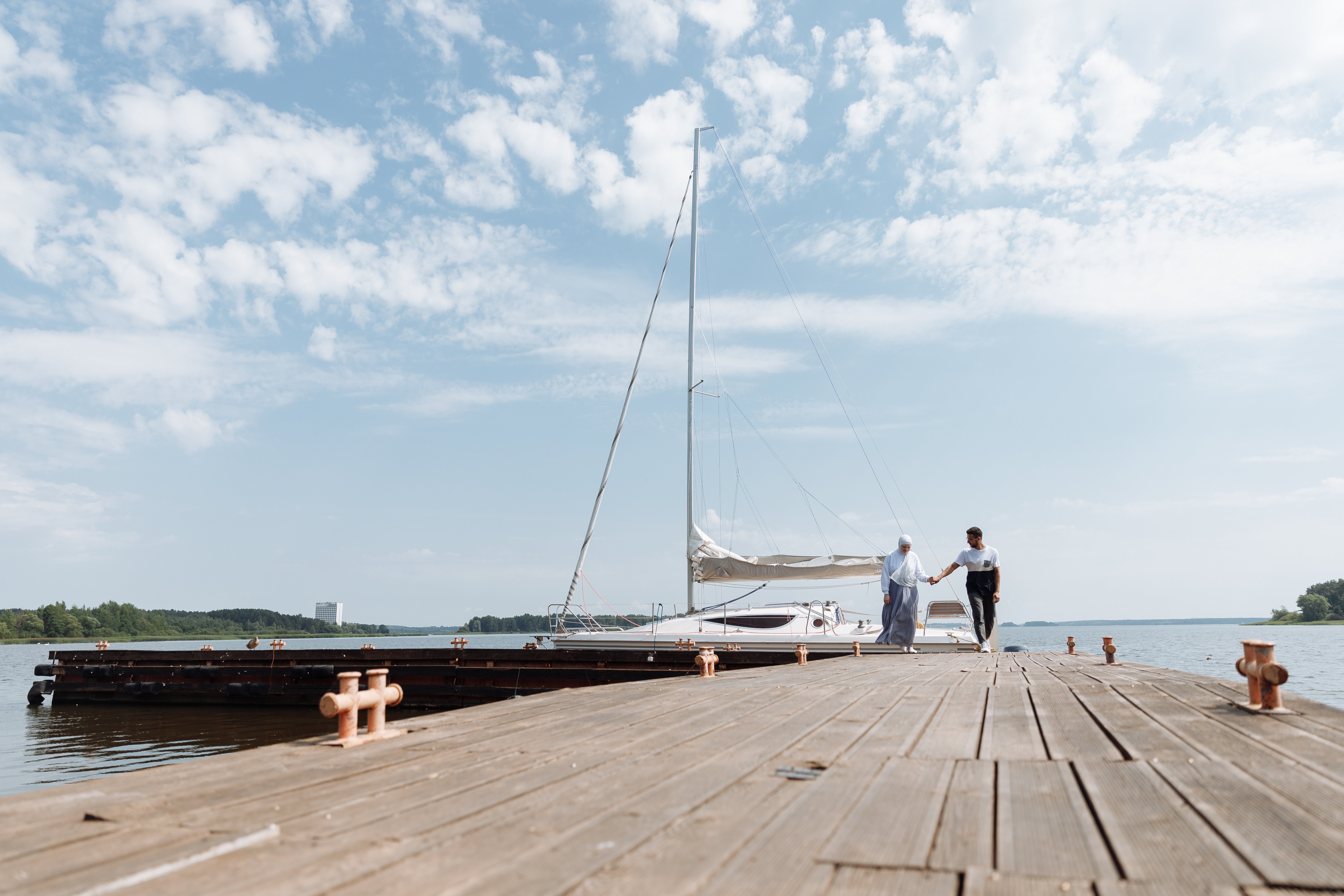 A Romantic Couple Walking on a Wooden Dock · Free Stock Photo