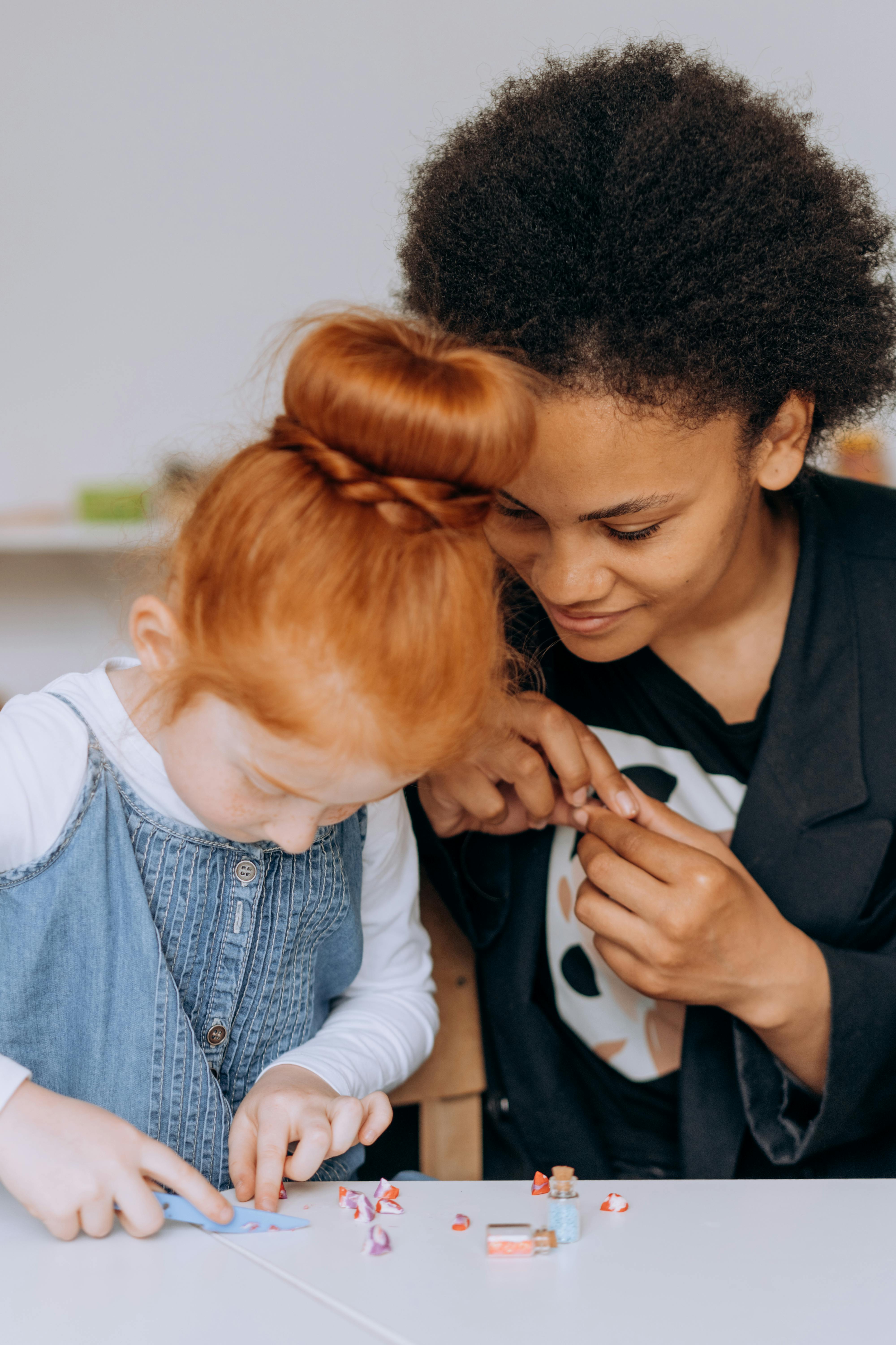 A Teacher Watching a Pupil Play with Educational Toys · Free Stock Photo