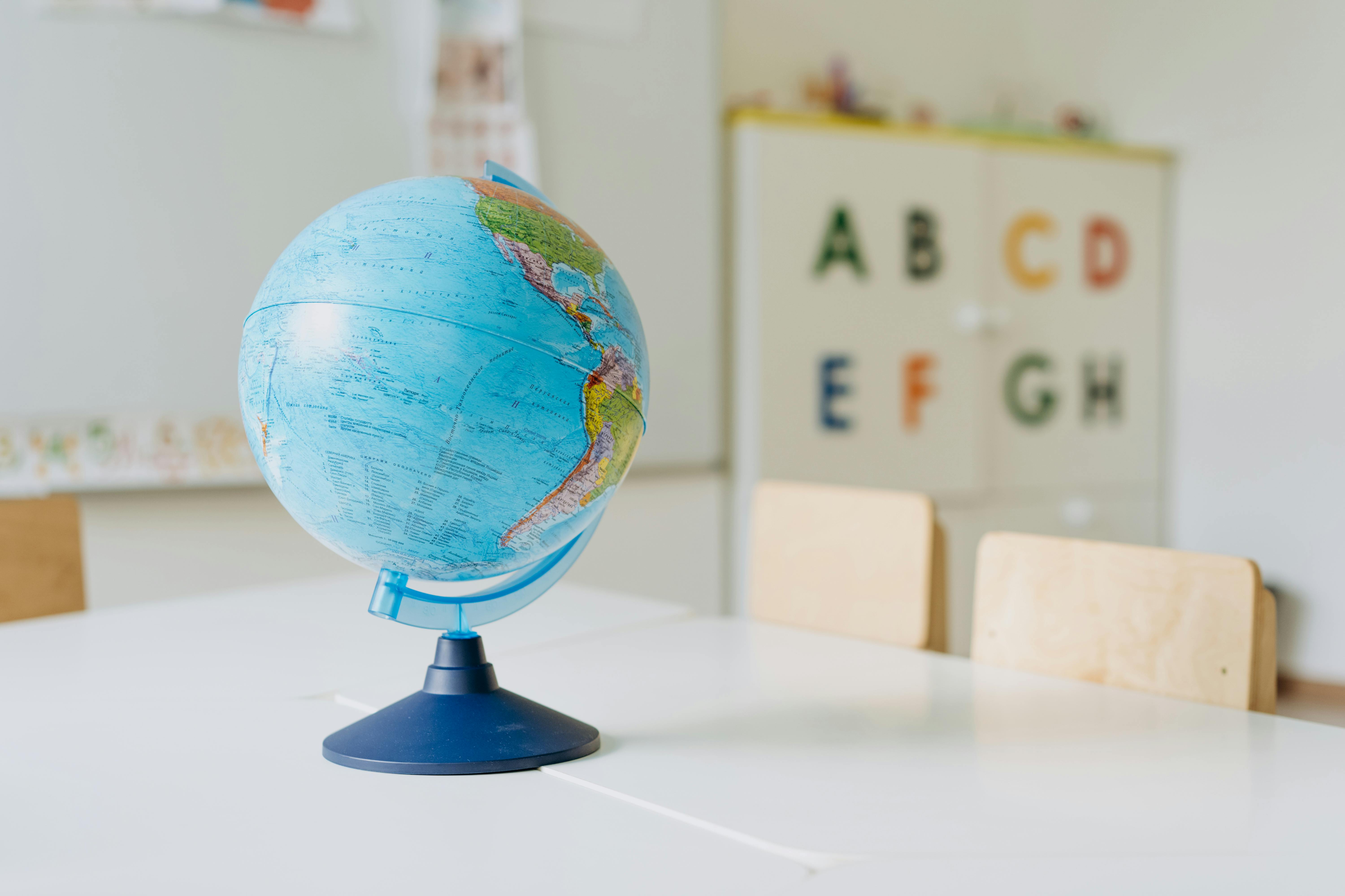 A Close-Up Shot of a Globe on a White Table · Free Stock Photo