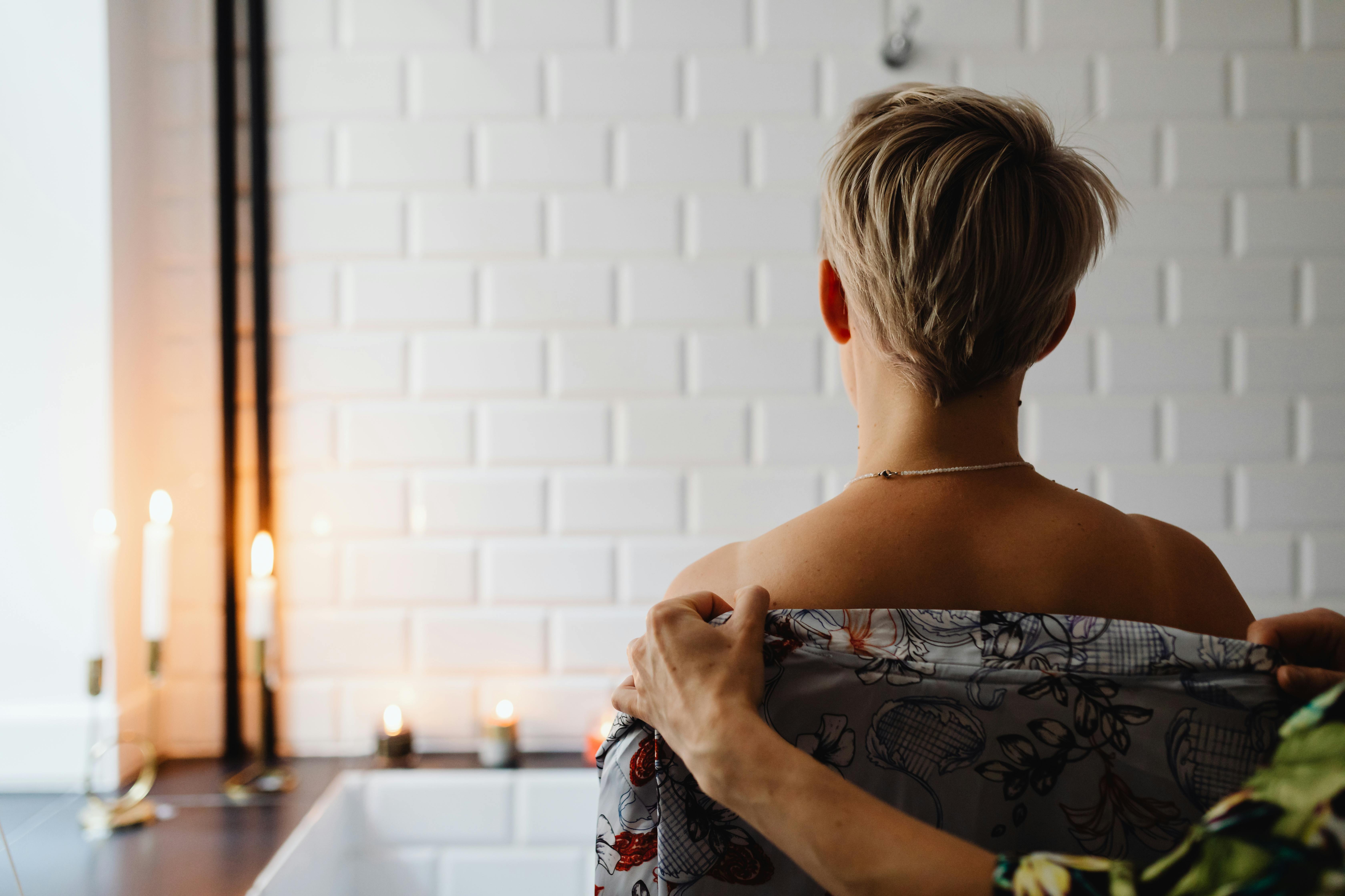 A Person Removing a Woman's Robe · Free Stock Photo
