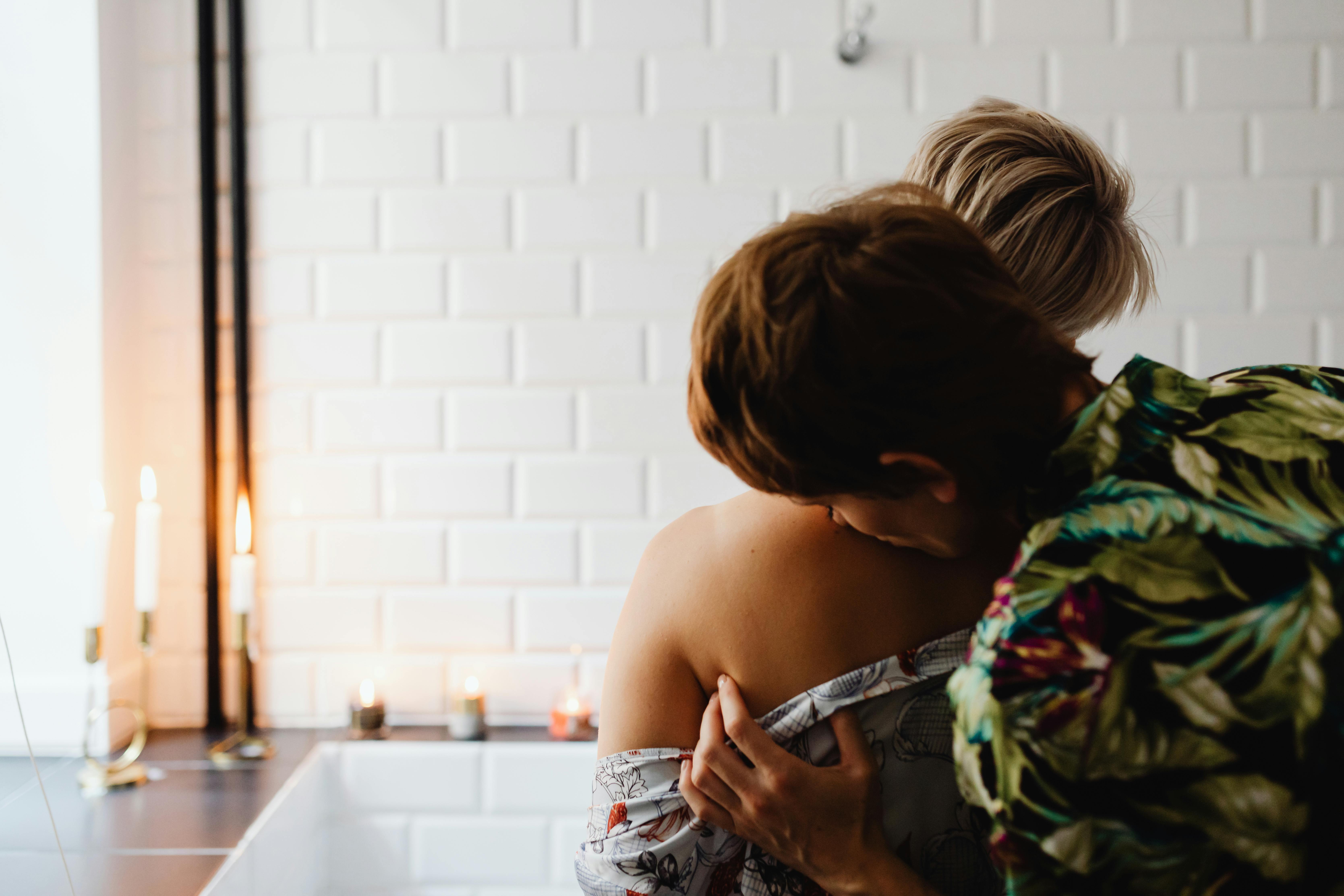A Woman Kissing another Woman's Back · Free Stock Photo