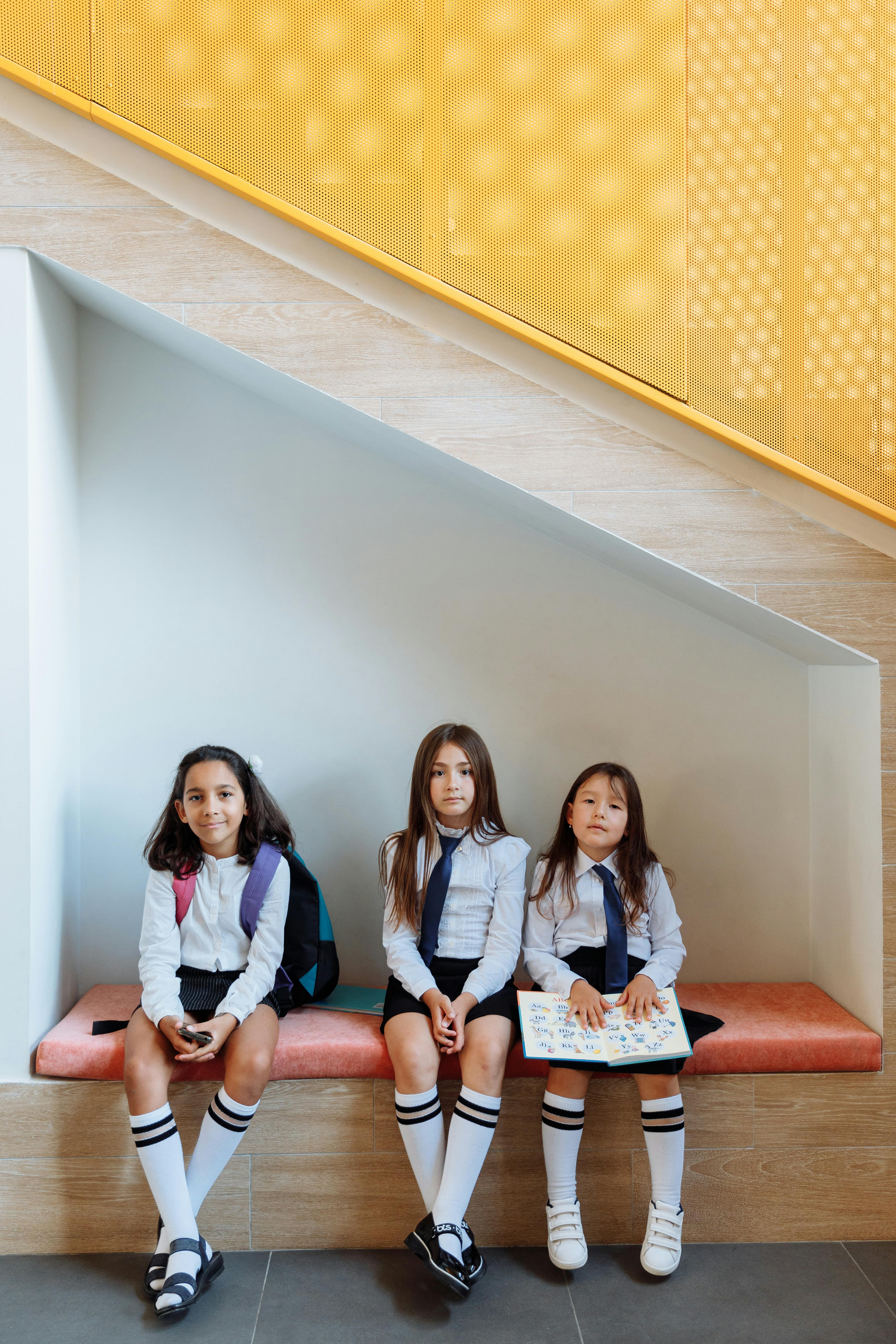 Three Girls in School Uniform Sitting on the Bench · Free Stock Photo