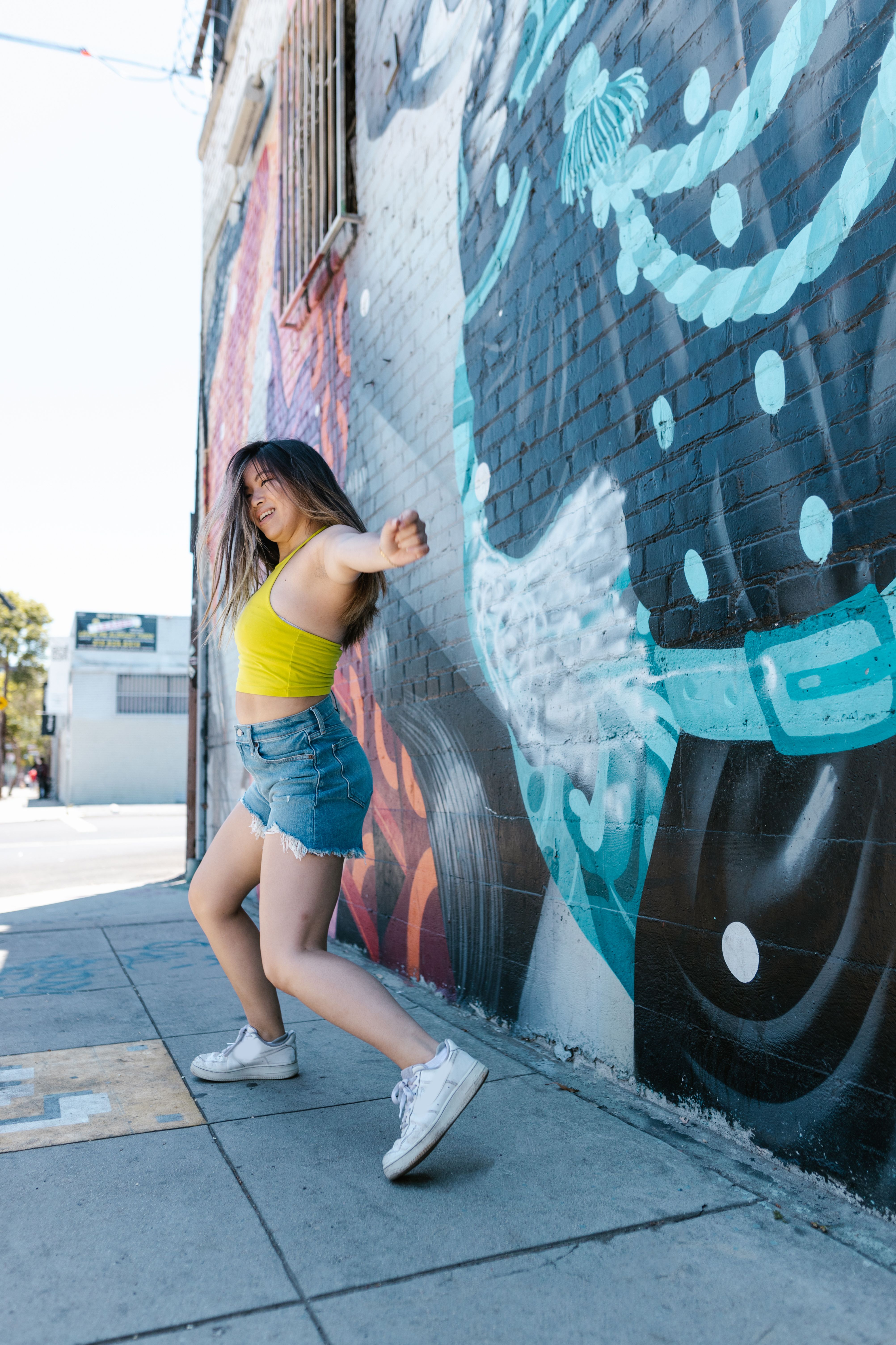 A Young Man Dancing by a Brick Wall · Free Stock Photo