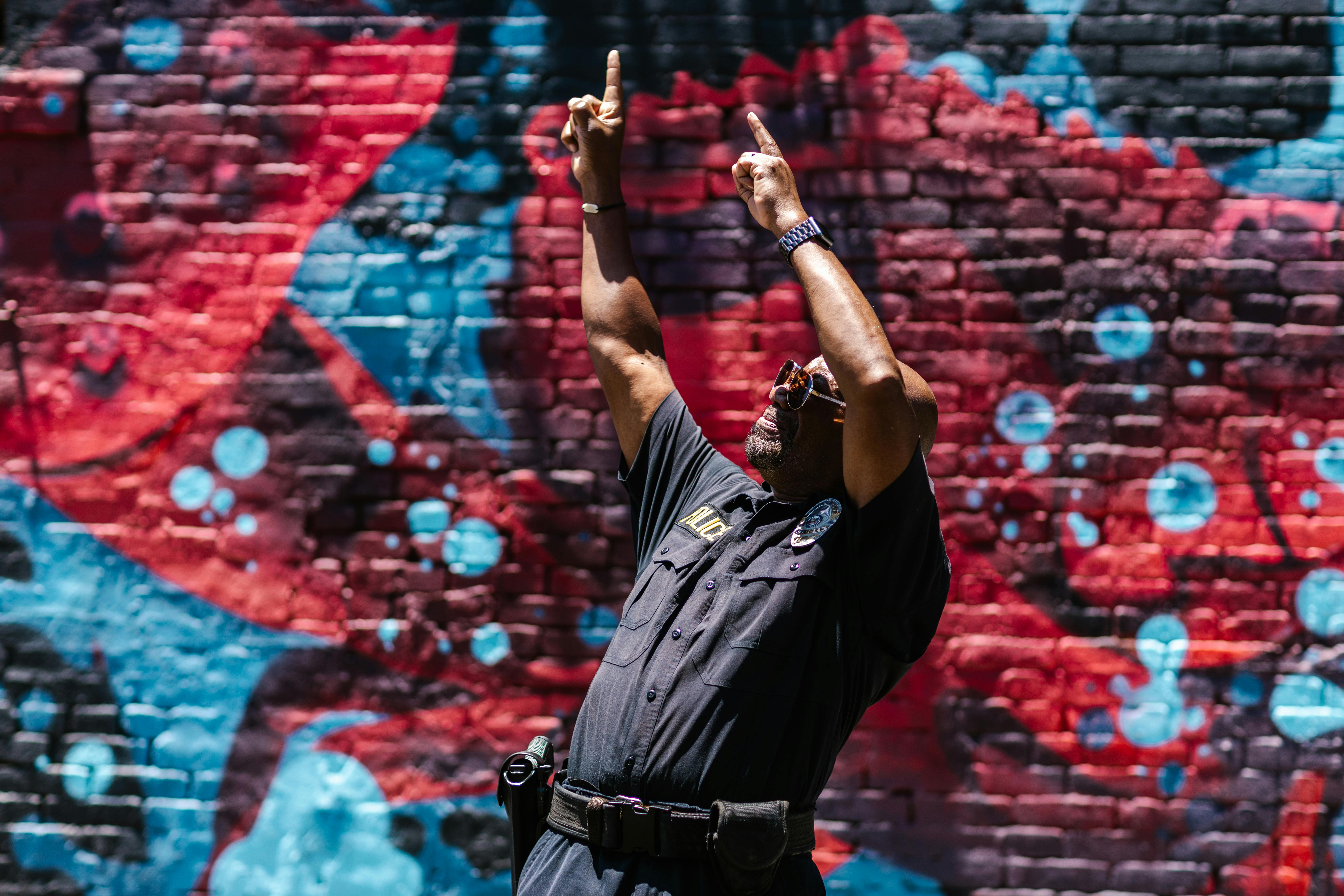 A Policeman Leaning on a Brick Wall · Free Stock Photo