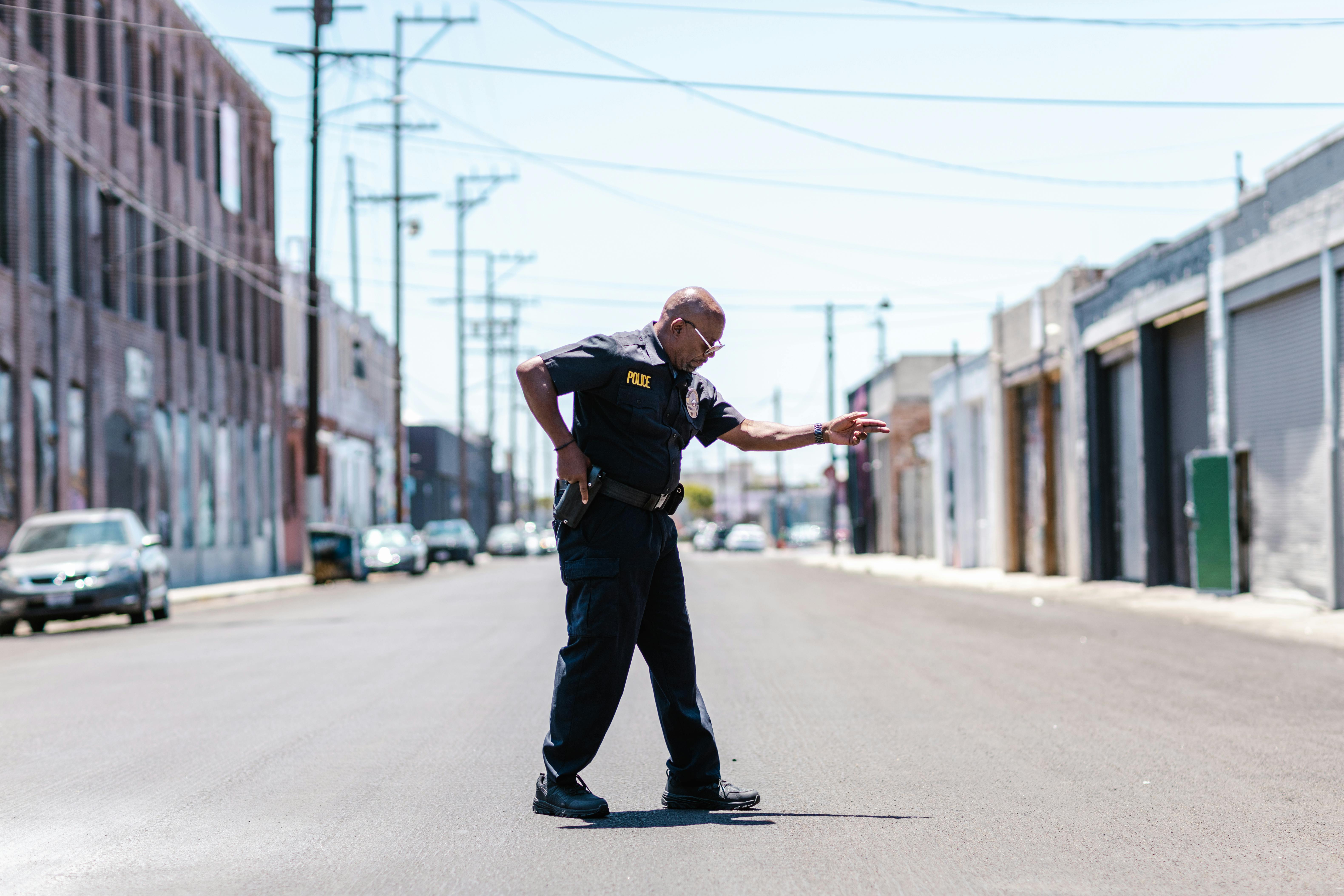 A Police Officer Frisking the Person in Yellow T-Shirt · Free Stock Photo