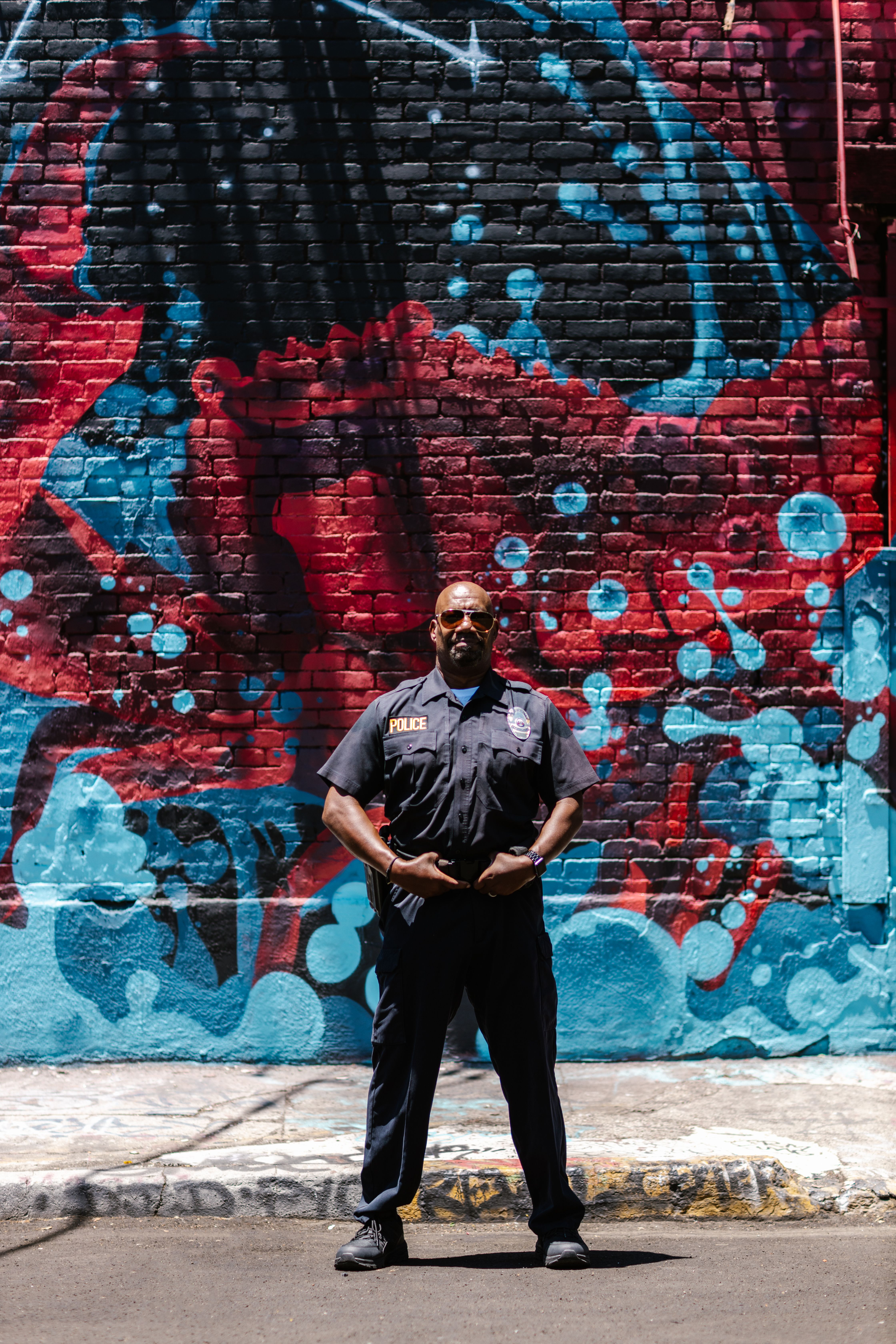 Man in Police Uniform against Mural · Free Stock Photo