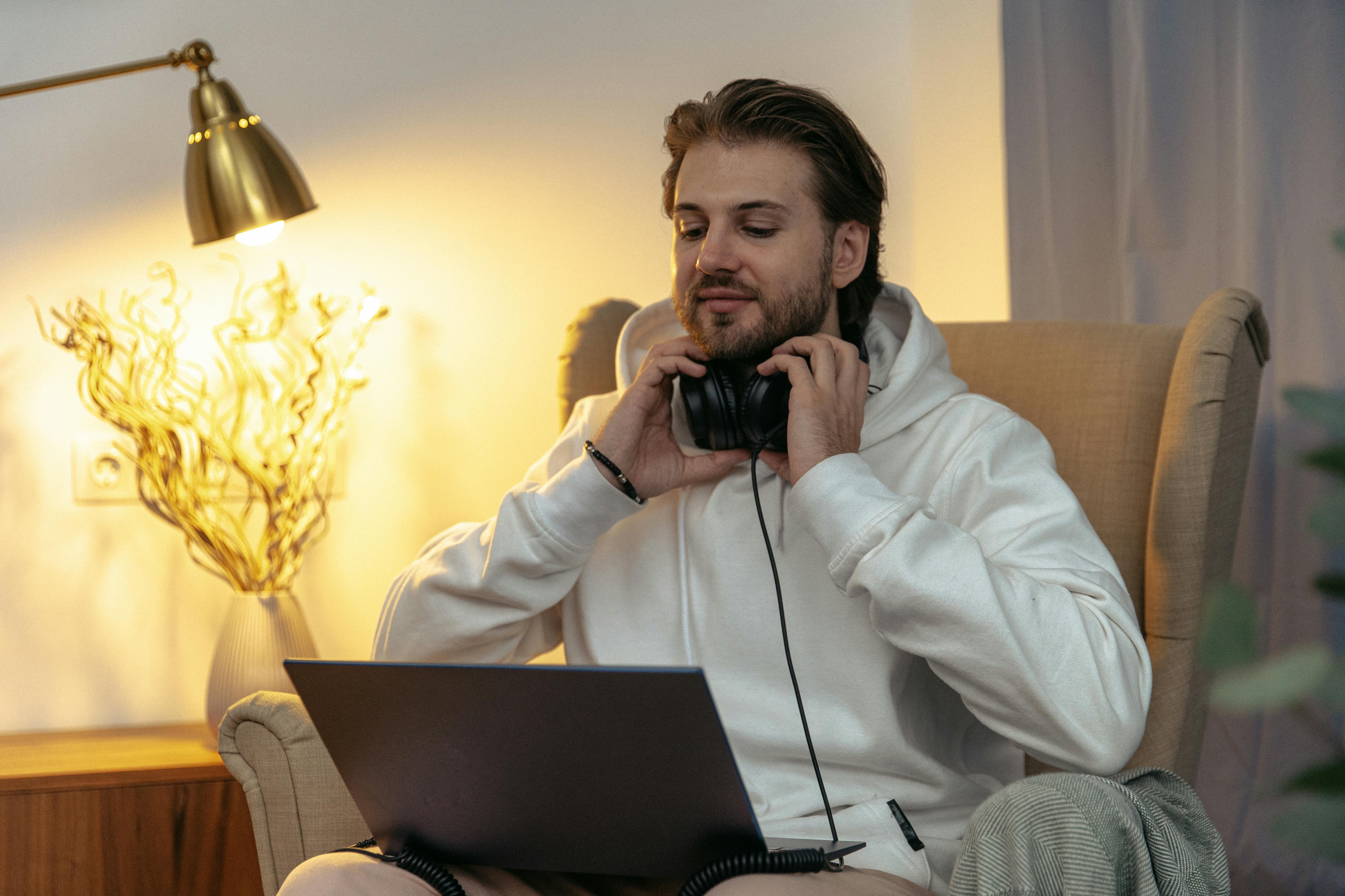A Man Wearing Hoodie Jacket Using a Laptop · Free Stock Photo