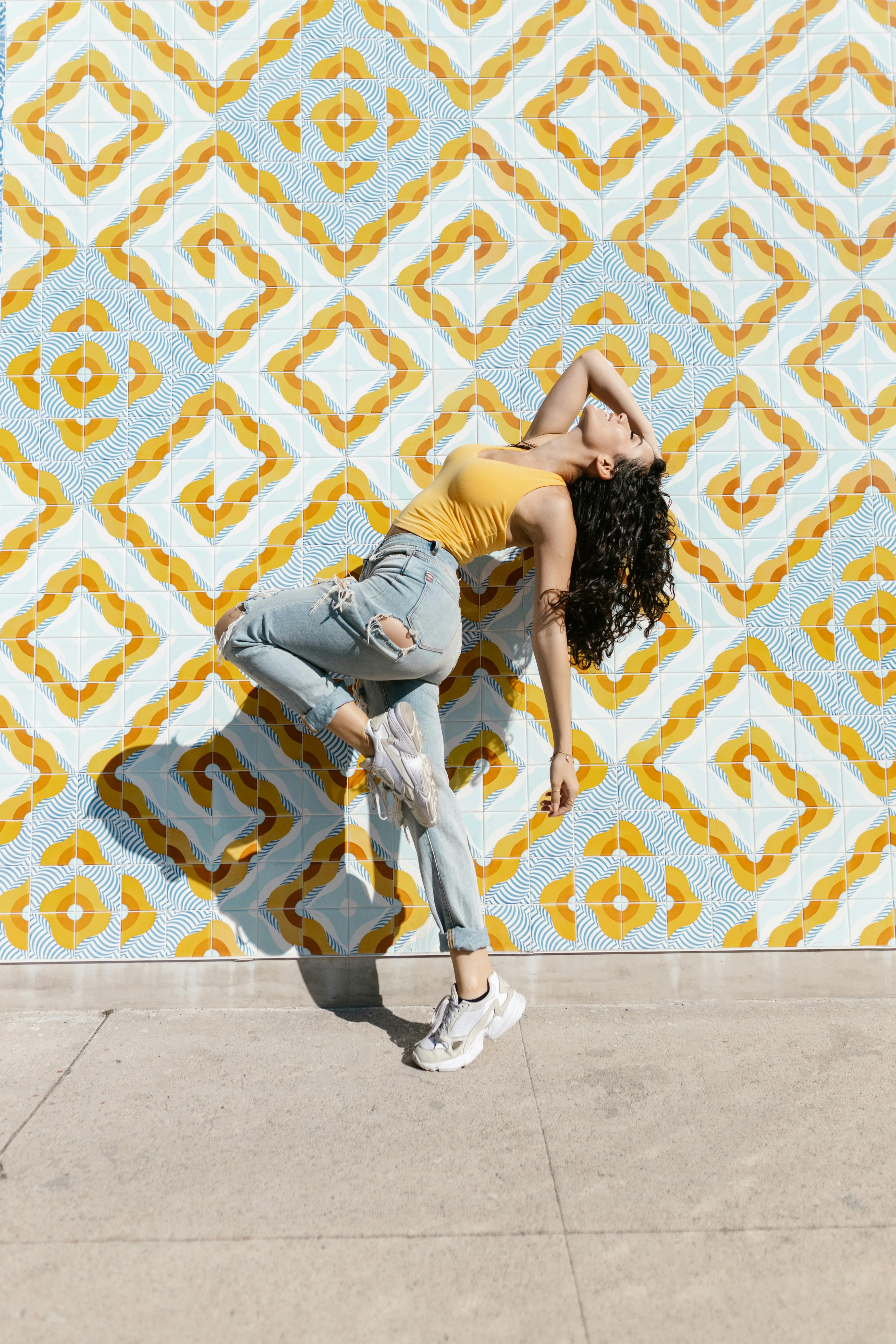 Woman in Yellow Tank Top and Blue Denim Shorts Dancing · Free Stock Photo