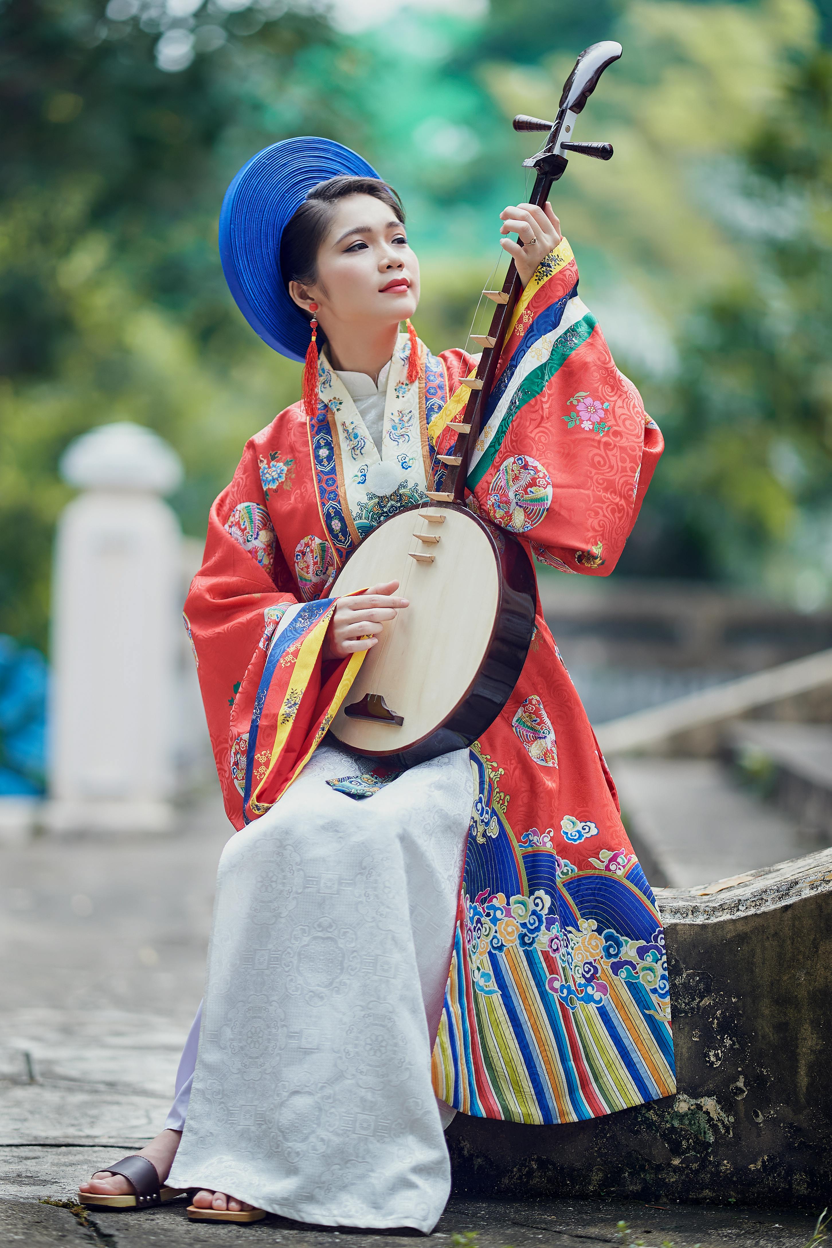Woman in Traditional Clothes Playing Instrument · Free Stock Photo