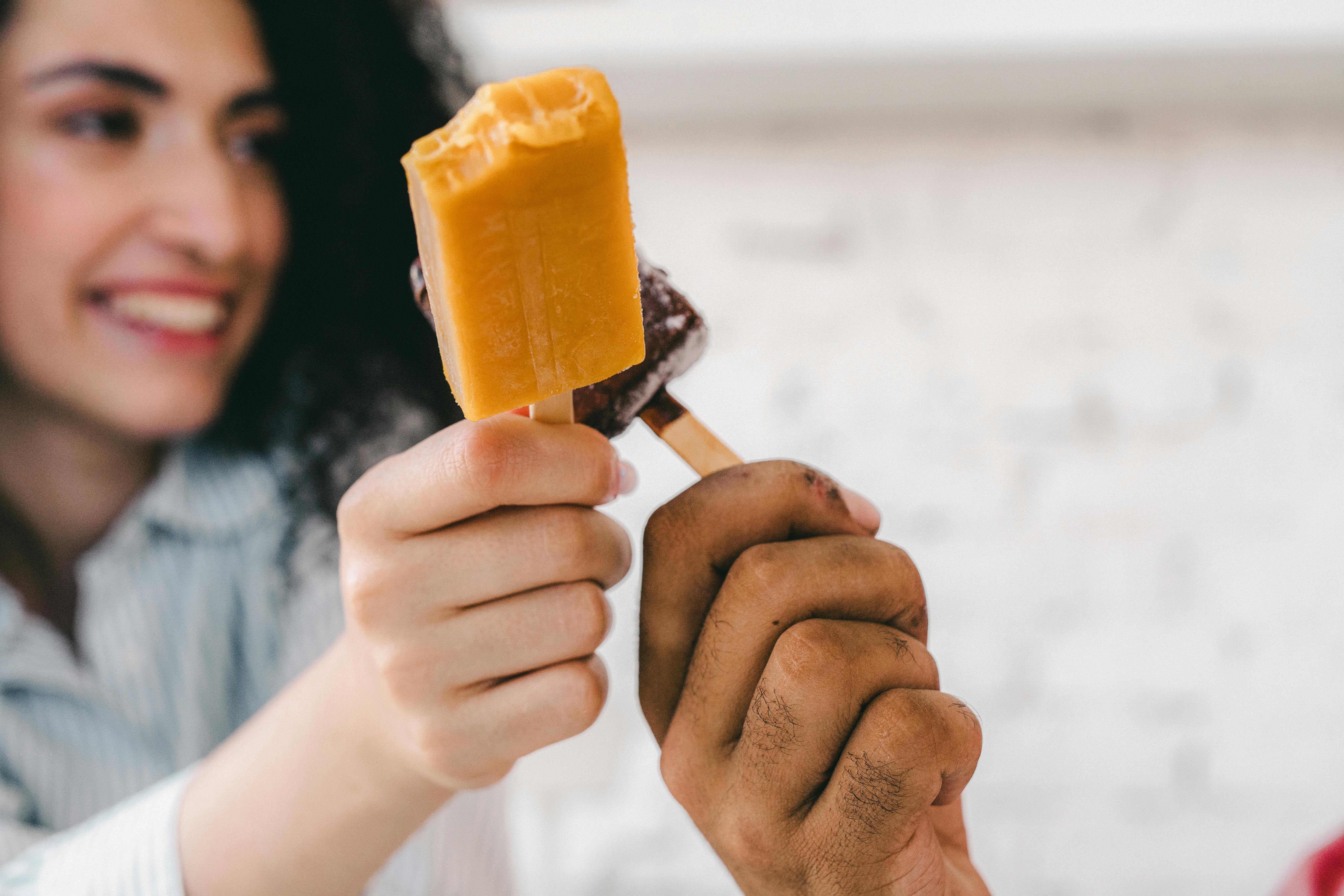Close-Up Photograph of Hands Holding Popsicle Sticks · Free Stock Photo