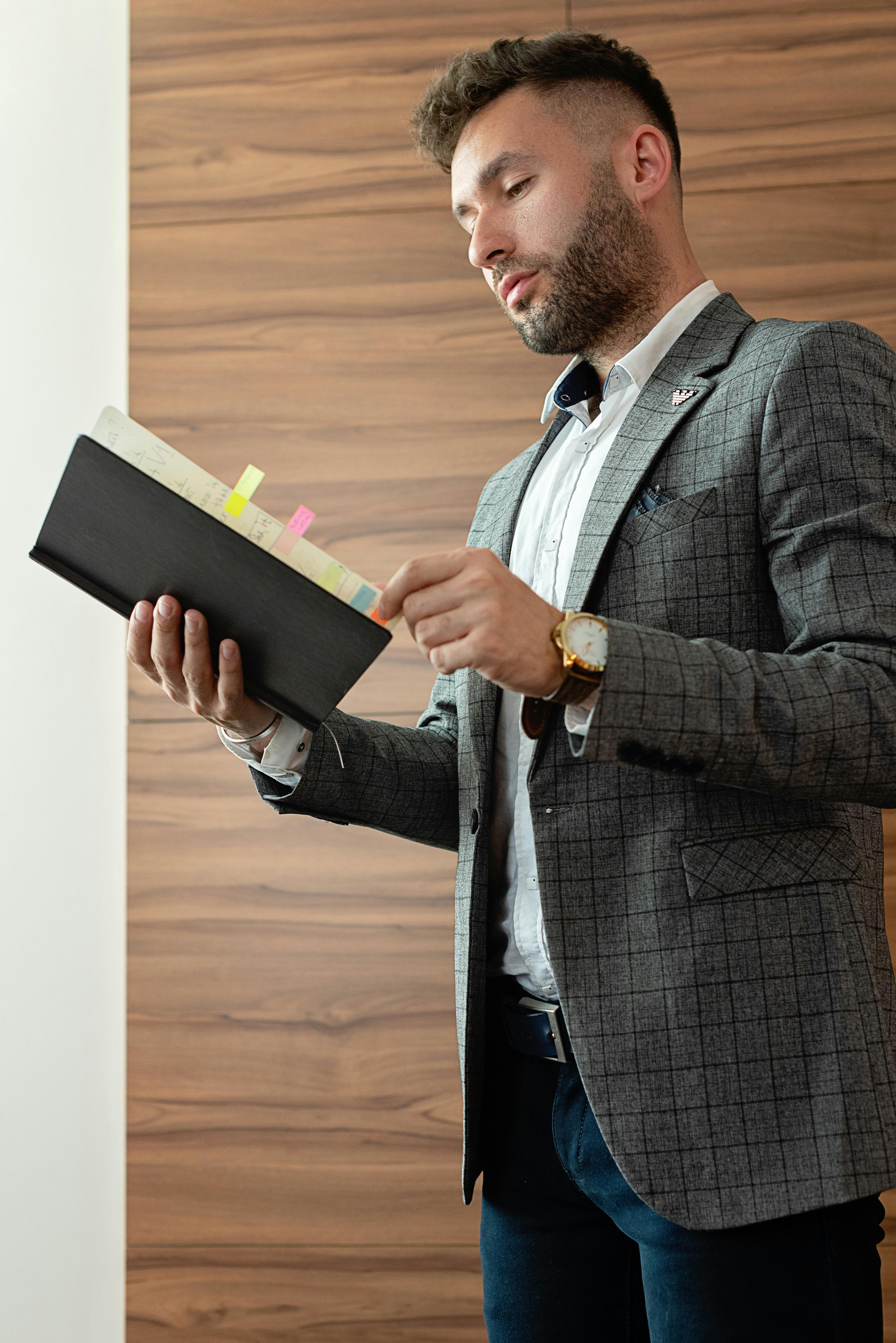 Man Standing while Holding a Book · Free Stock Photo