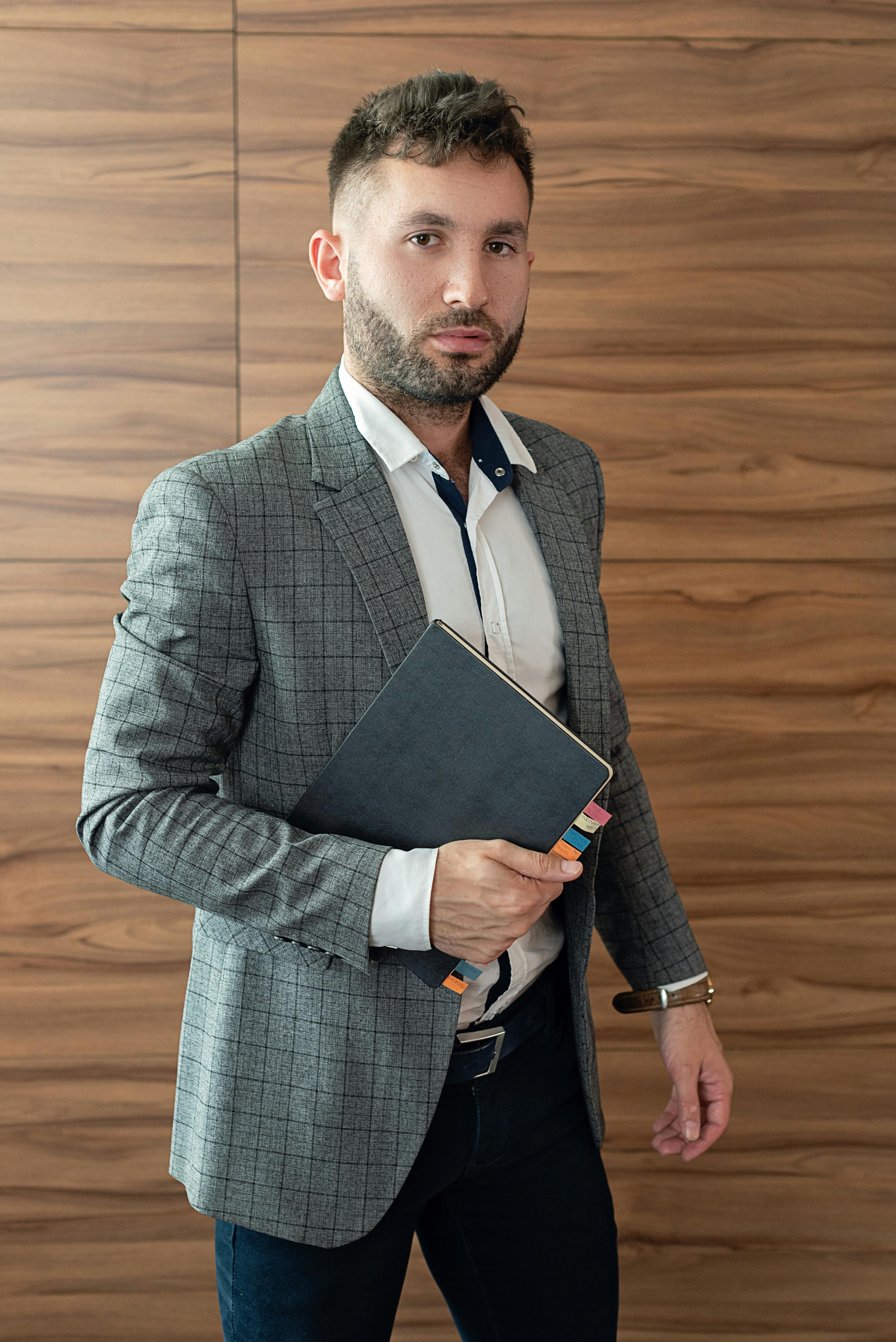 Man in Gray Suit Holding a Notebook · Free Stock Photo