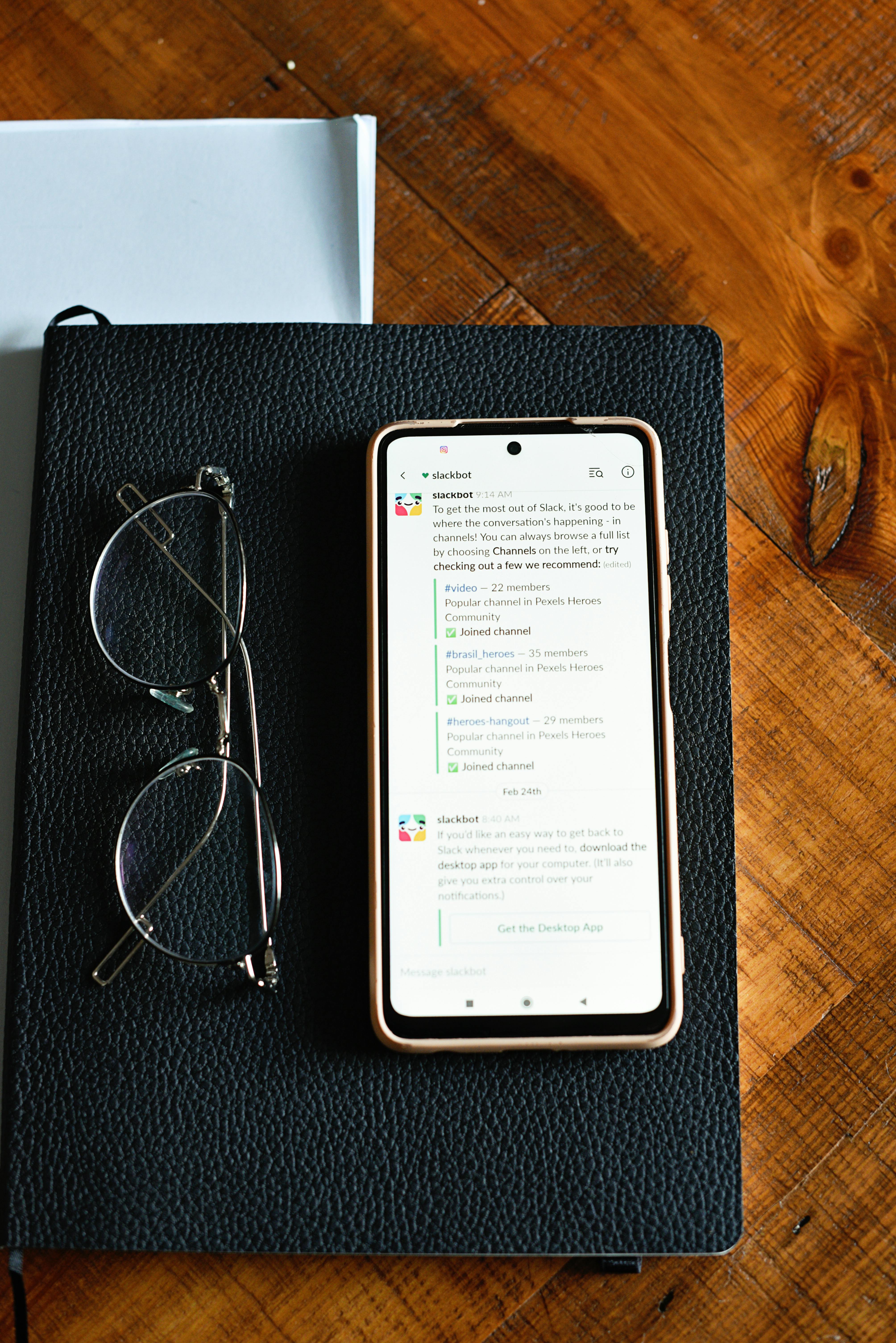 A Smartphone and Eyeglasses on the Notepad · Free Stock Photo