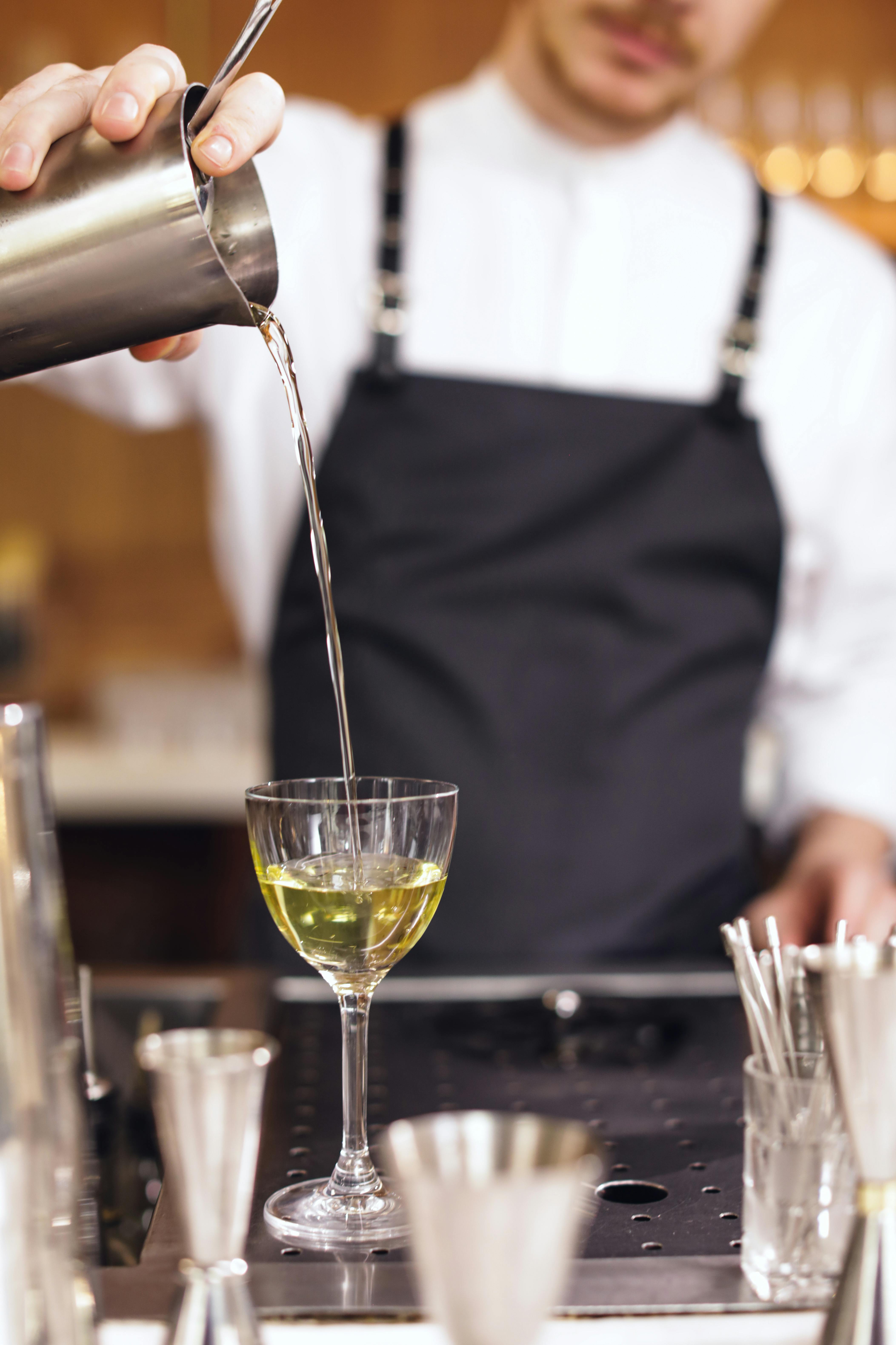 A Bartender Pouring a Drink into a Glass · Free Stock Photo