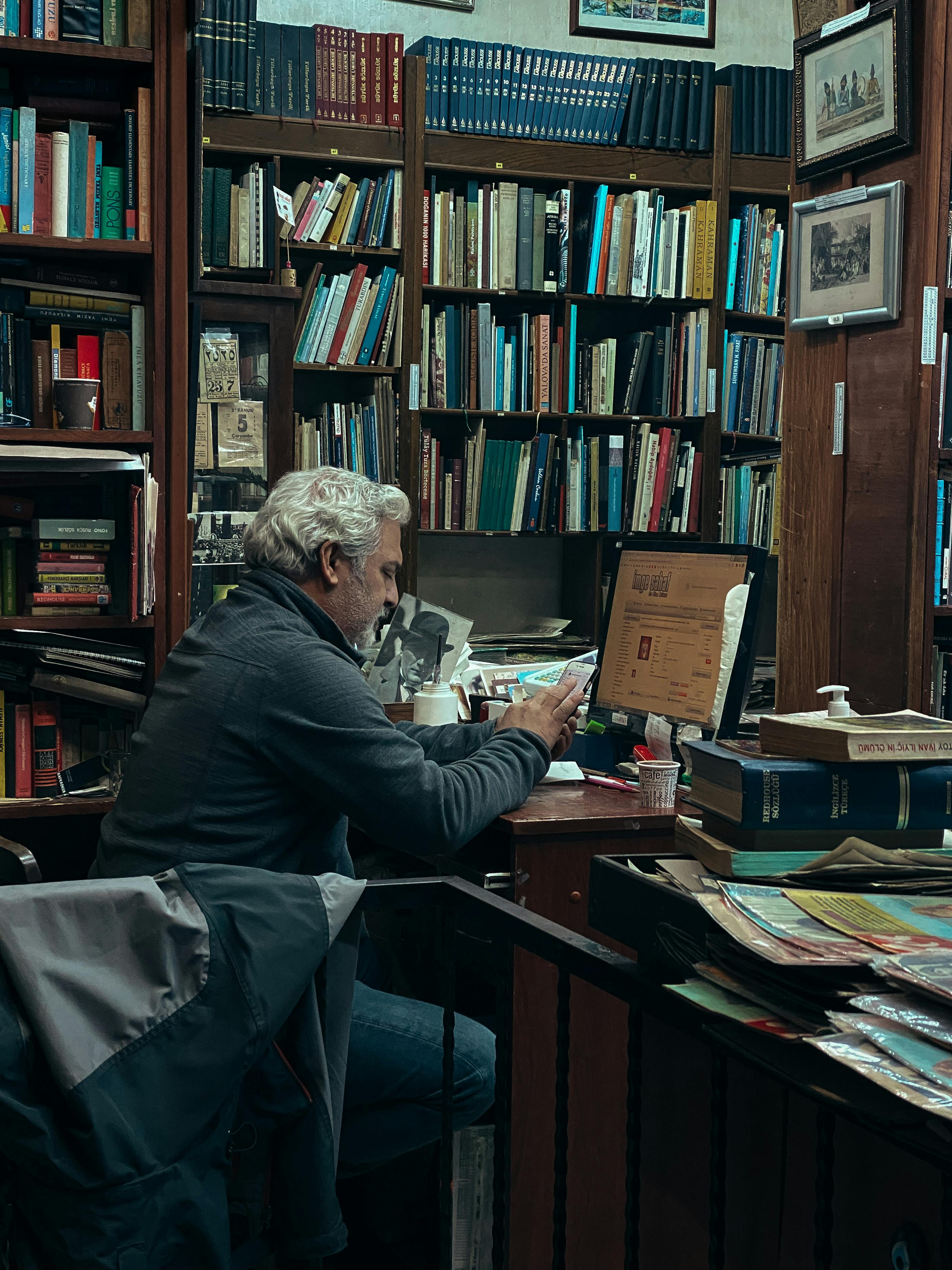 Man Sitting on a Chair in Front of Computer Laptop Using Cellphone ...
