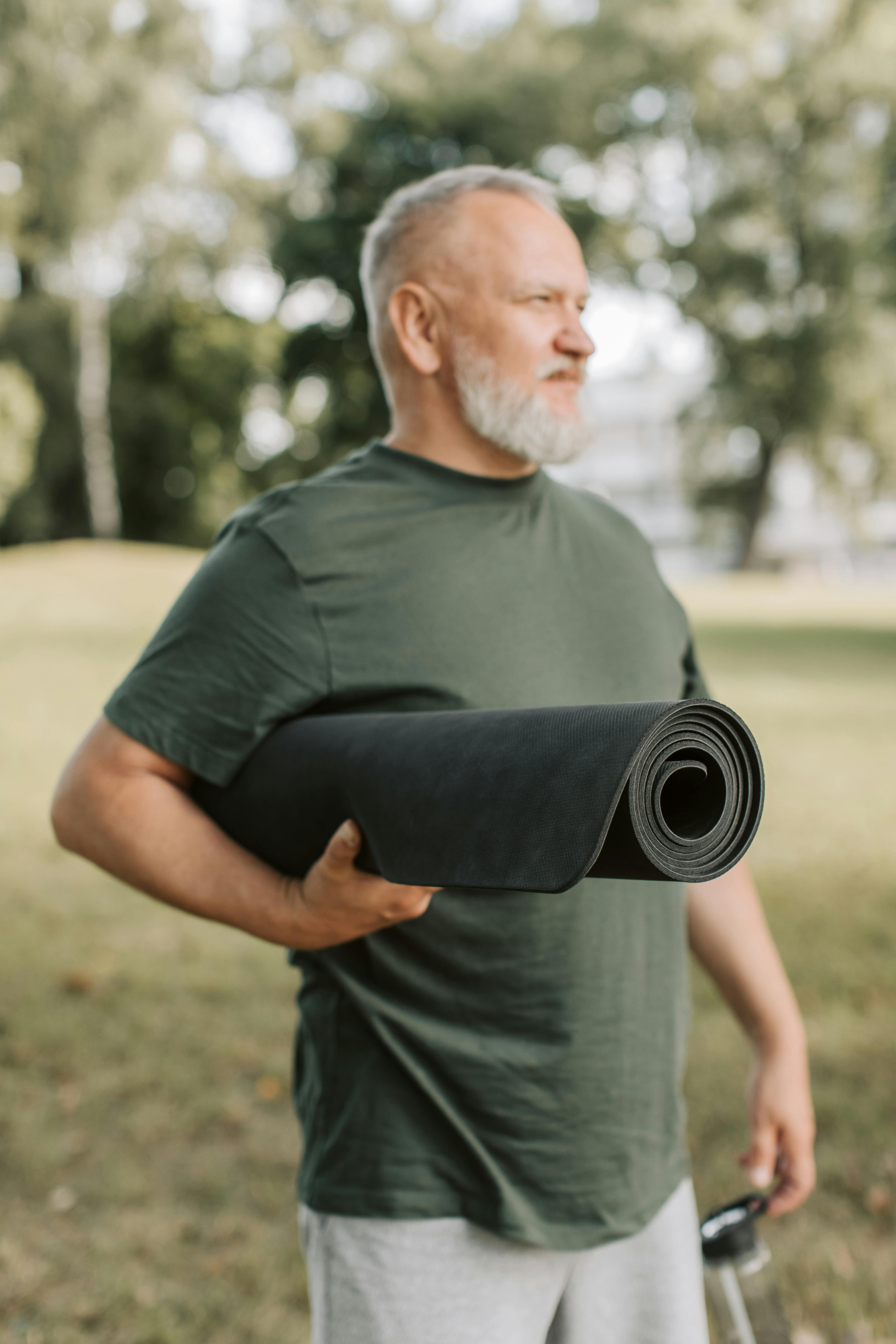 A Man Carrying a Yoga Mat · Free Stock Photo
