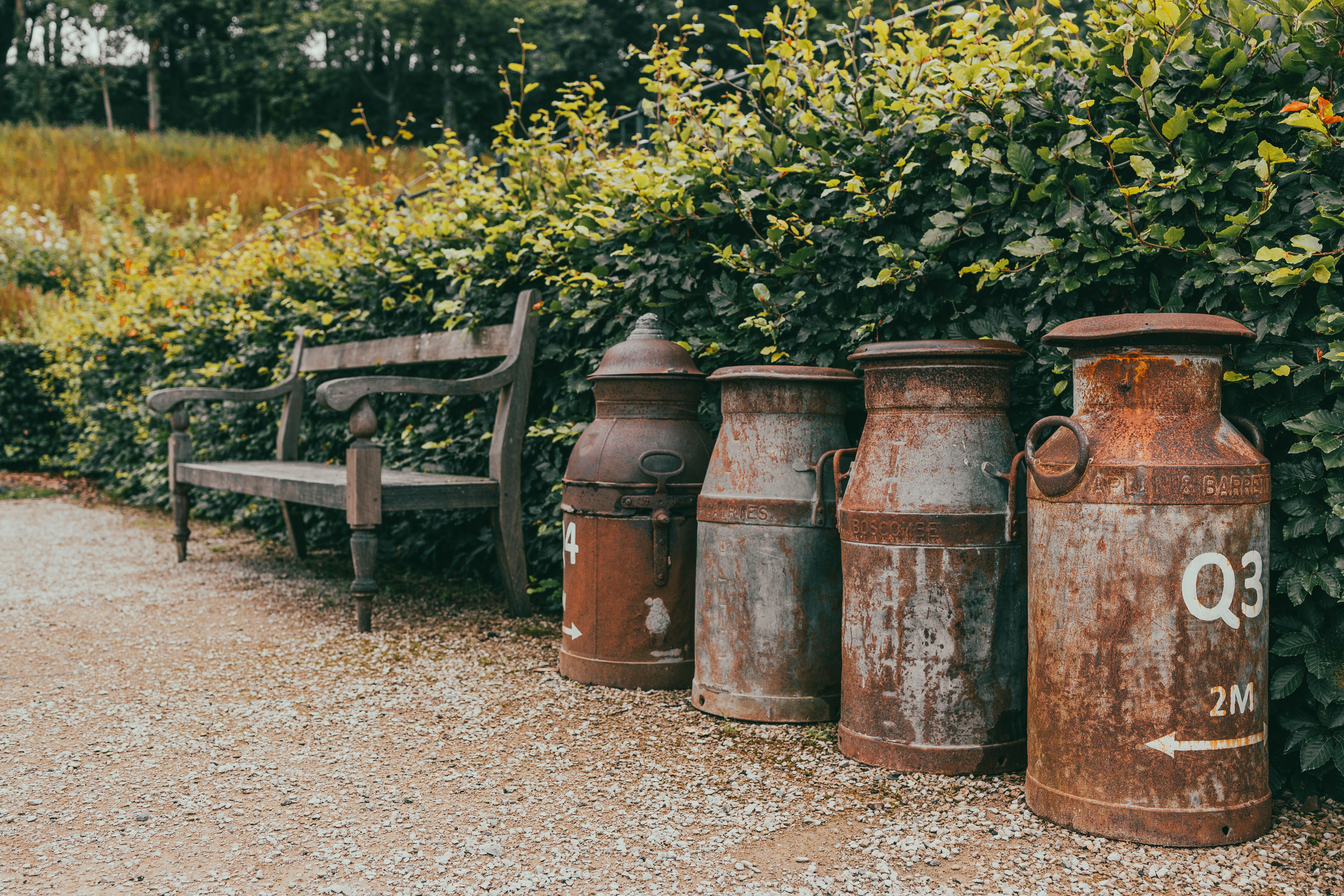 Rusty Cans by Bench in Park · Free Stock Photo
