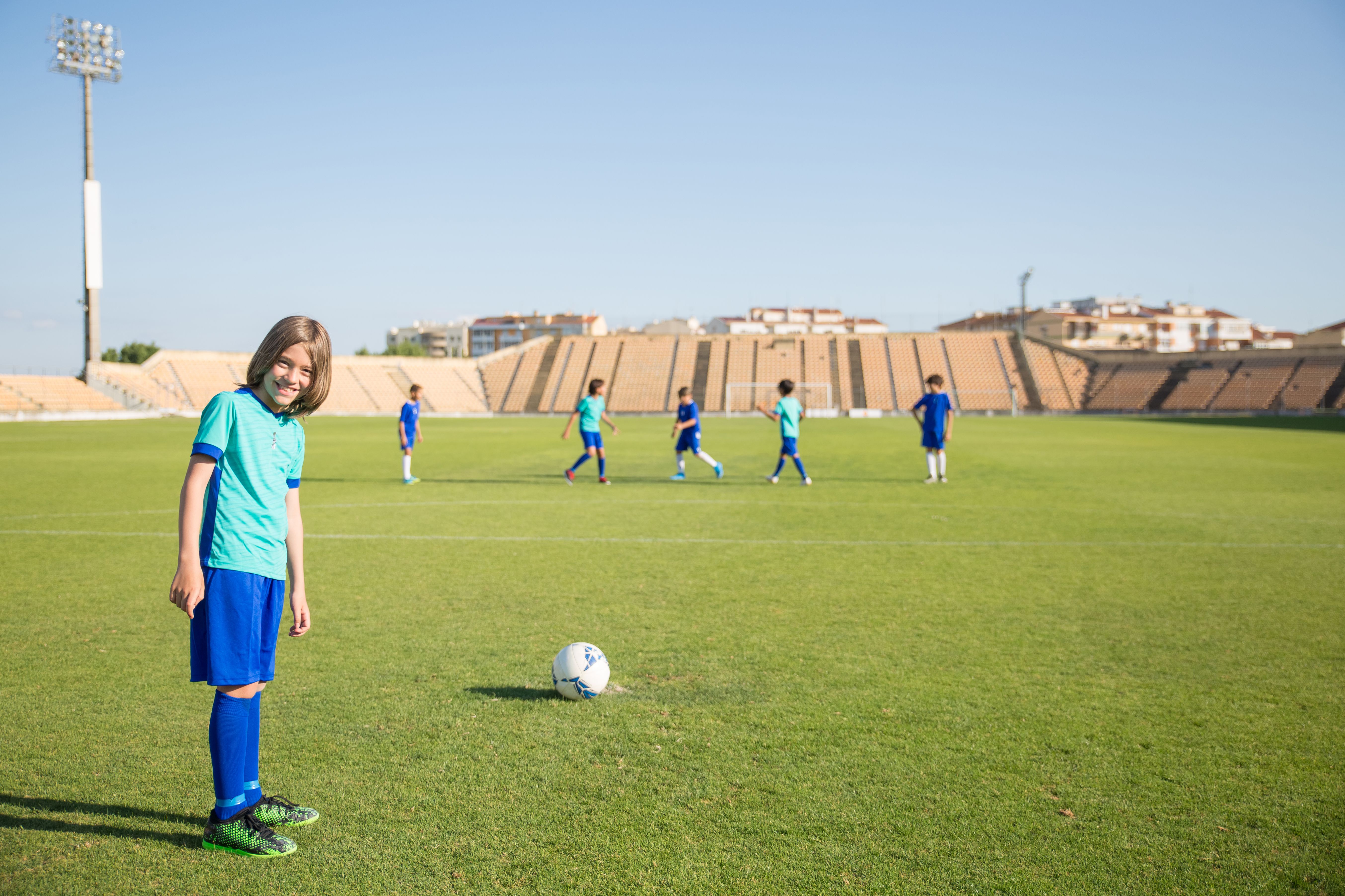 Children Wearing Jerseys Walking on a Football Field · Free Stock Photo