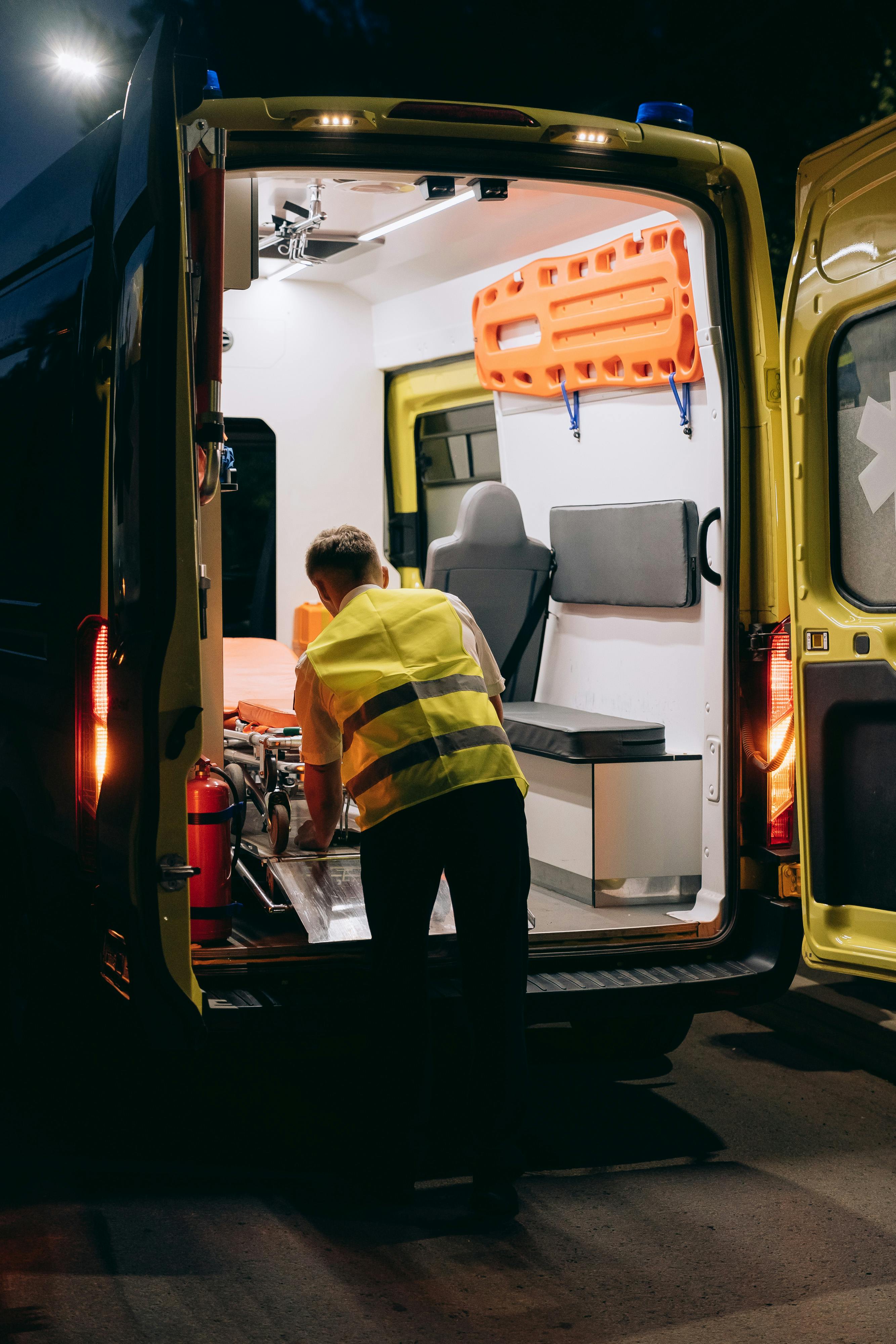 Back View of a Paramedic Taking the Gurney Out of the Ambulance · Free ...