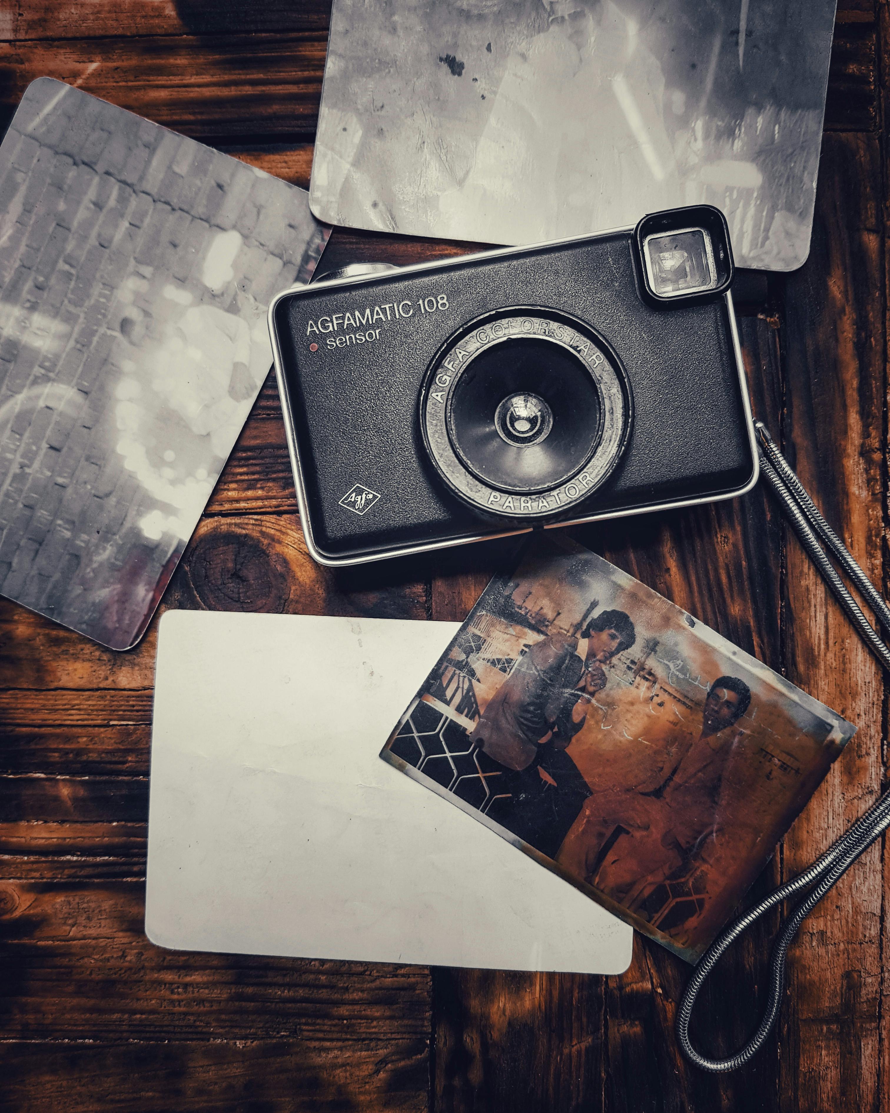 Old Photographs Besides a Vintage Camera · Free Stock Photo