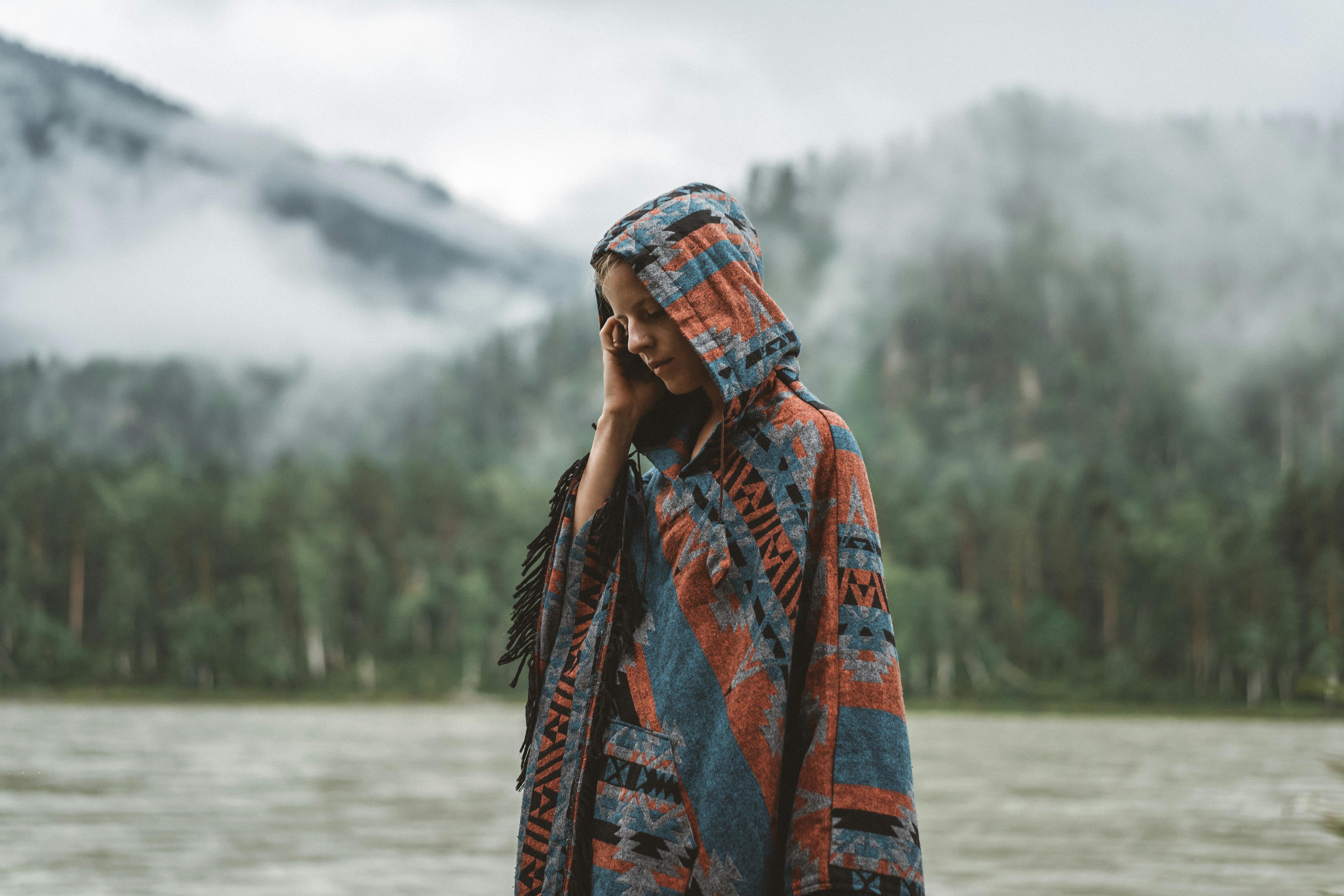 Woman Wearing Poncho Standing on Lake Shore · Free Stock Photo
