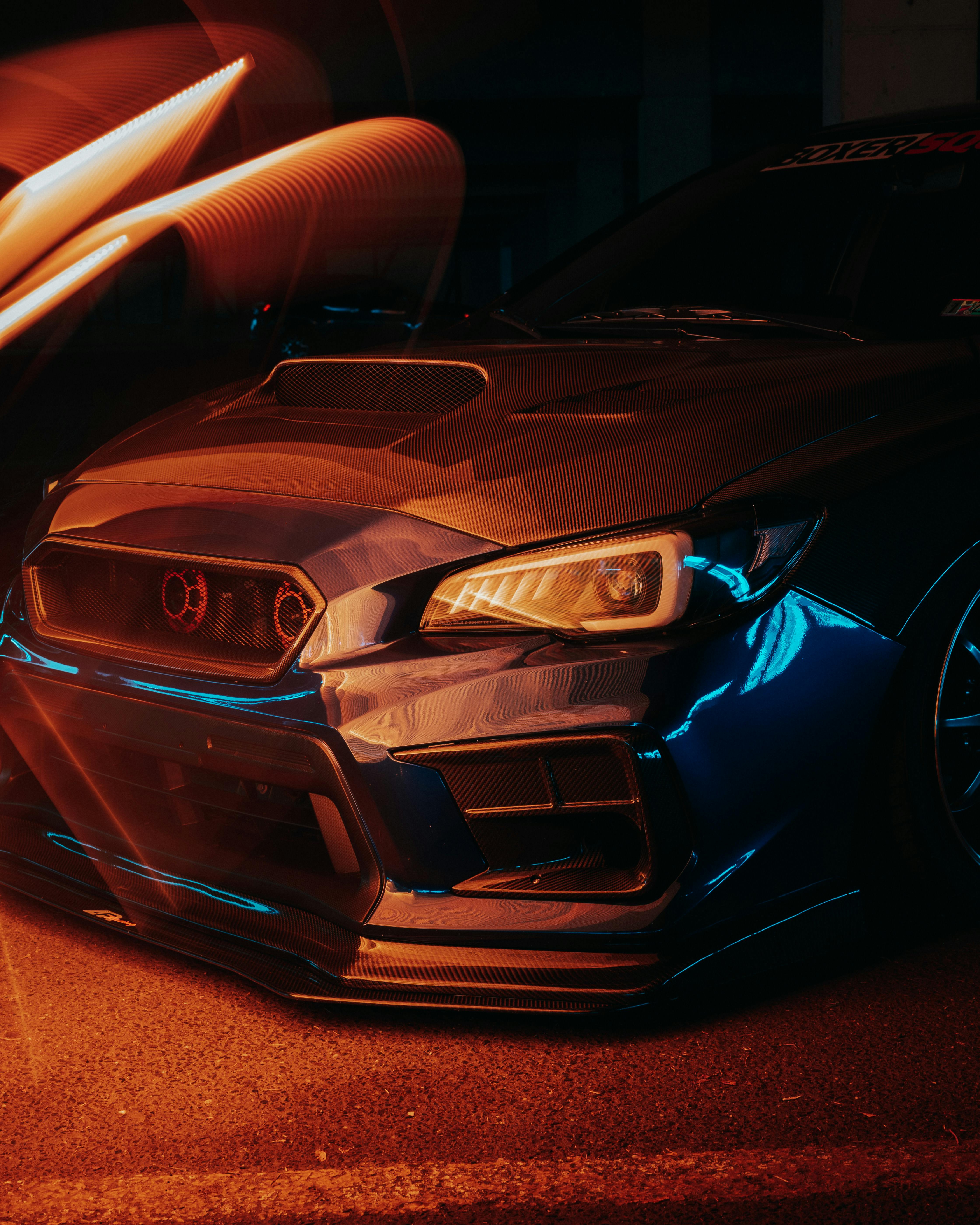A Shiny Sports Car on a Dark Road with Light Streaks · Free Stock Photo