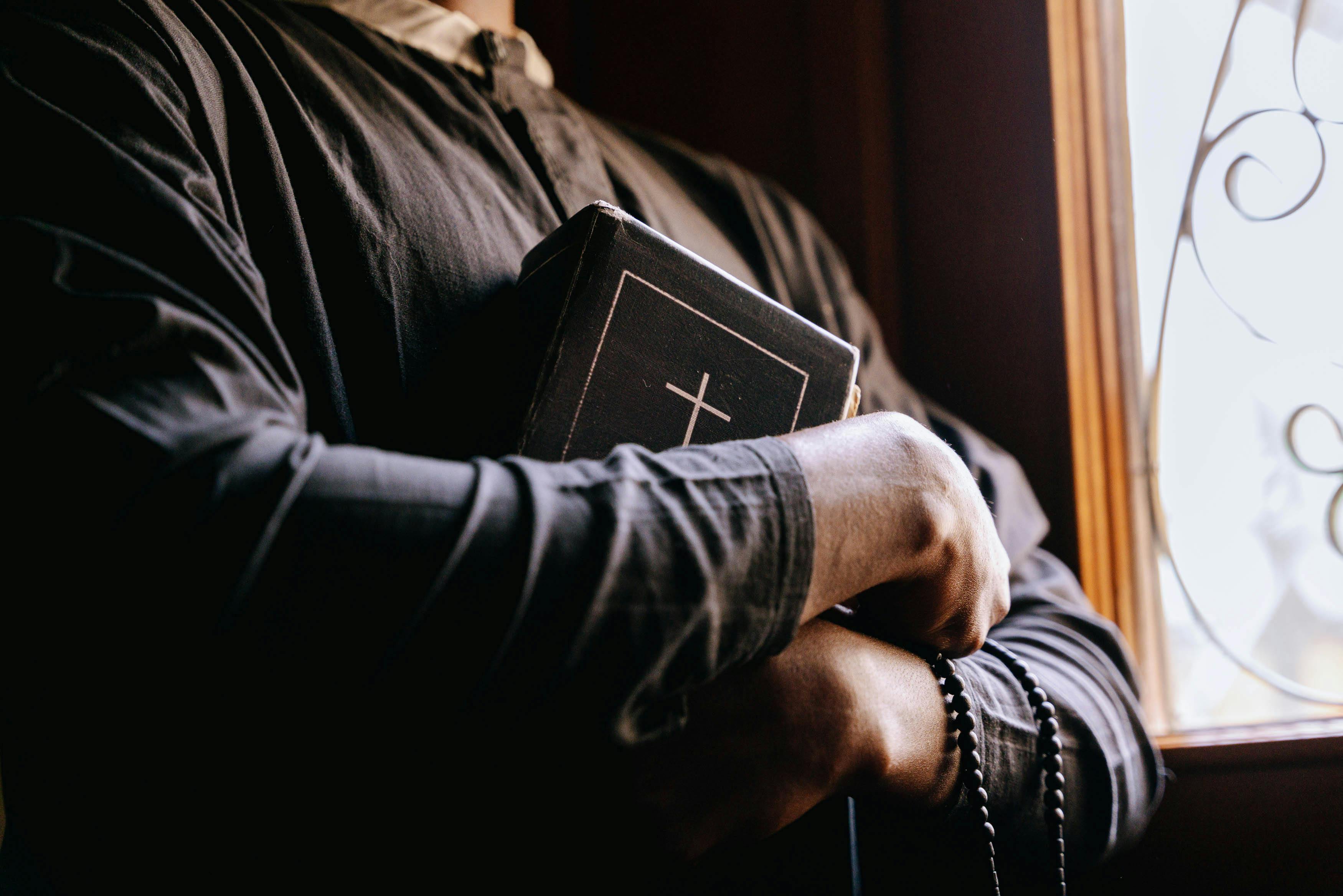 A Priest Holding a Bible · Free Stock Photo