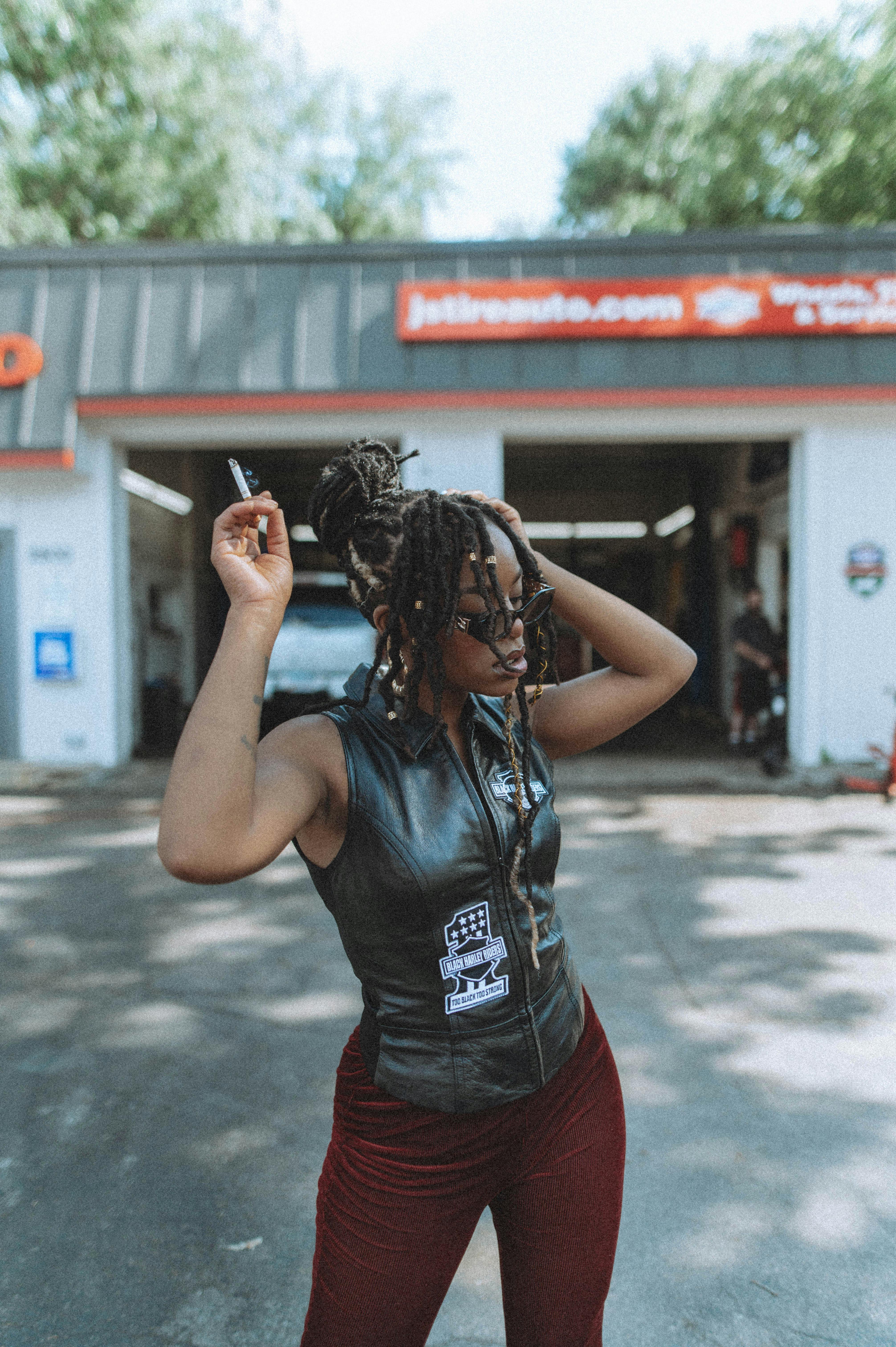 Woman with Sunglasses Sitting on Railing and Smoking Cigarette · Free ...