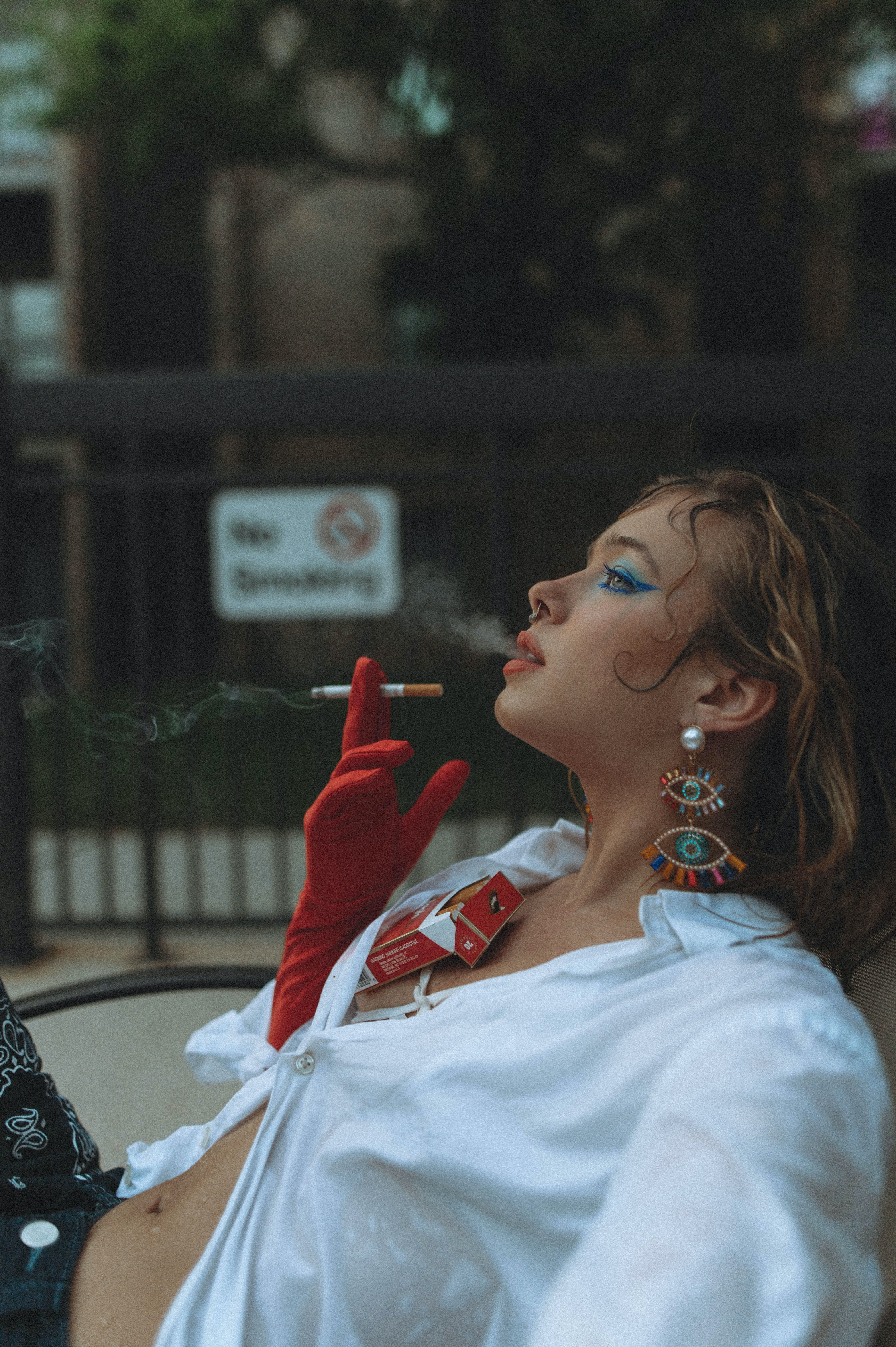 Woman in White Long Sleeves Smoking While Looking Up · Free Stock Photo