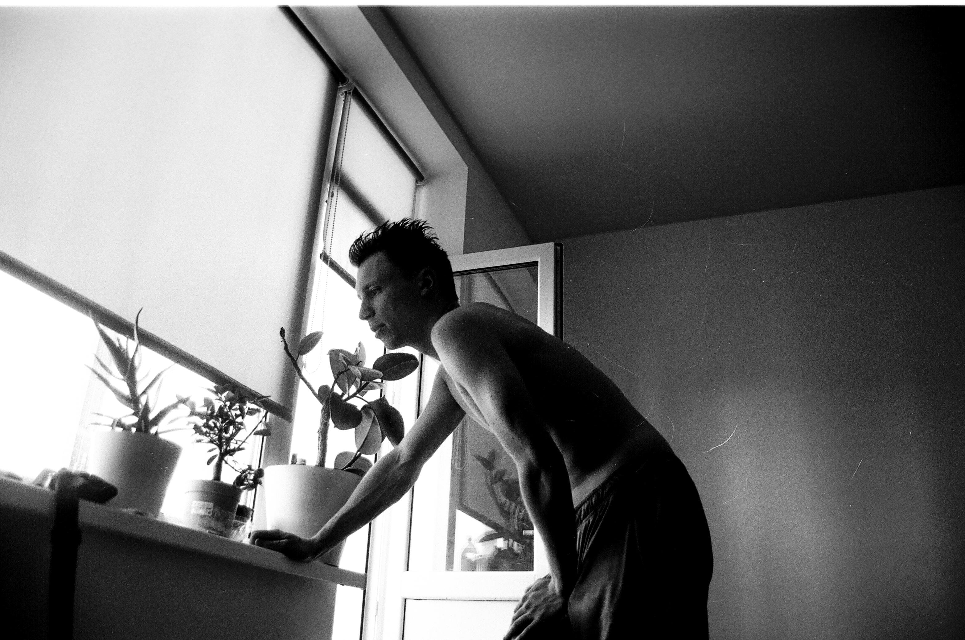 A Shirtless Man Standing by the Window · Free Stock Photo