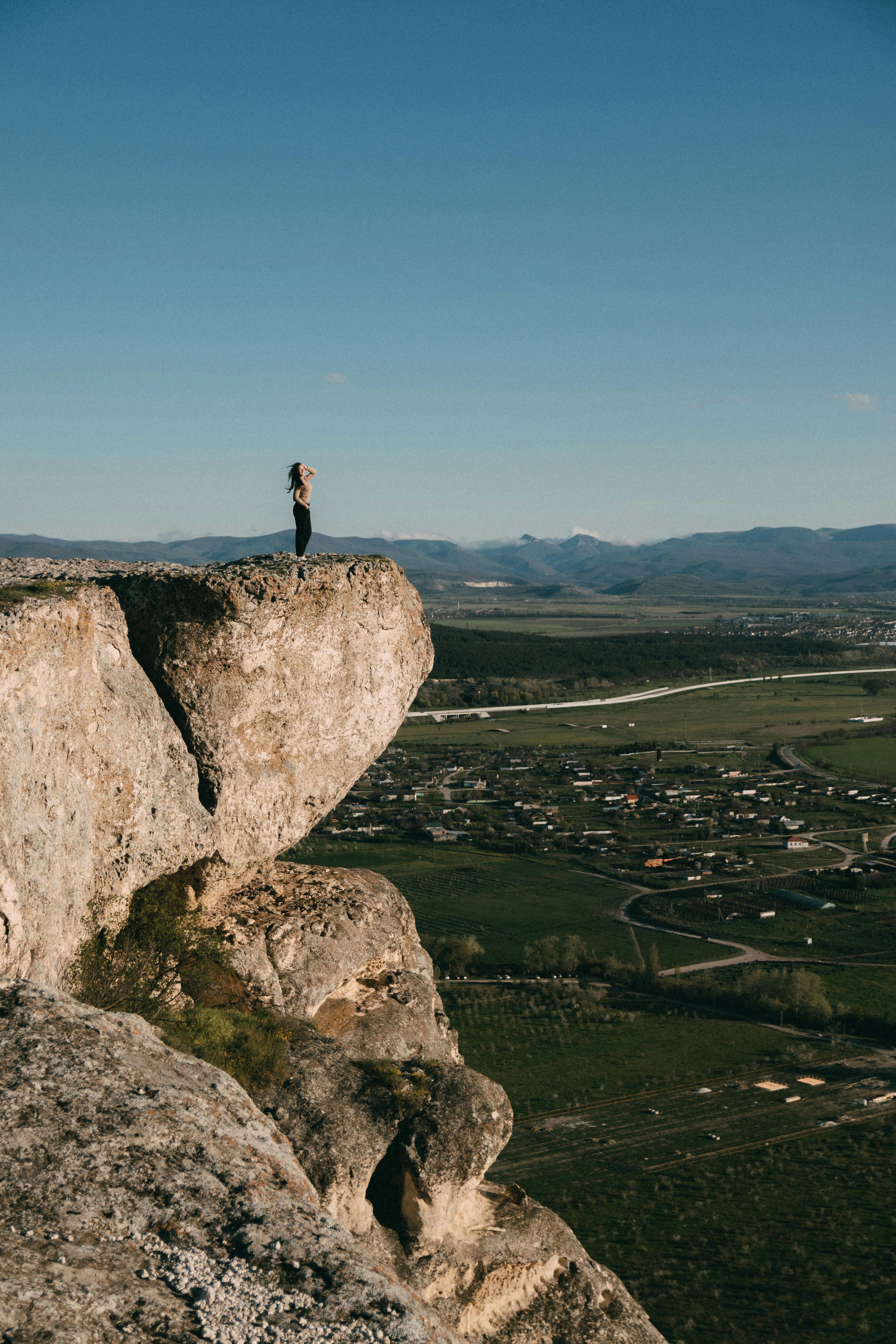 A Person Standing on a Rock Formation · Free Stock Photo
