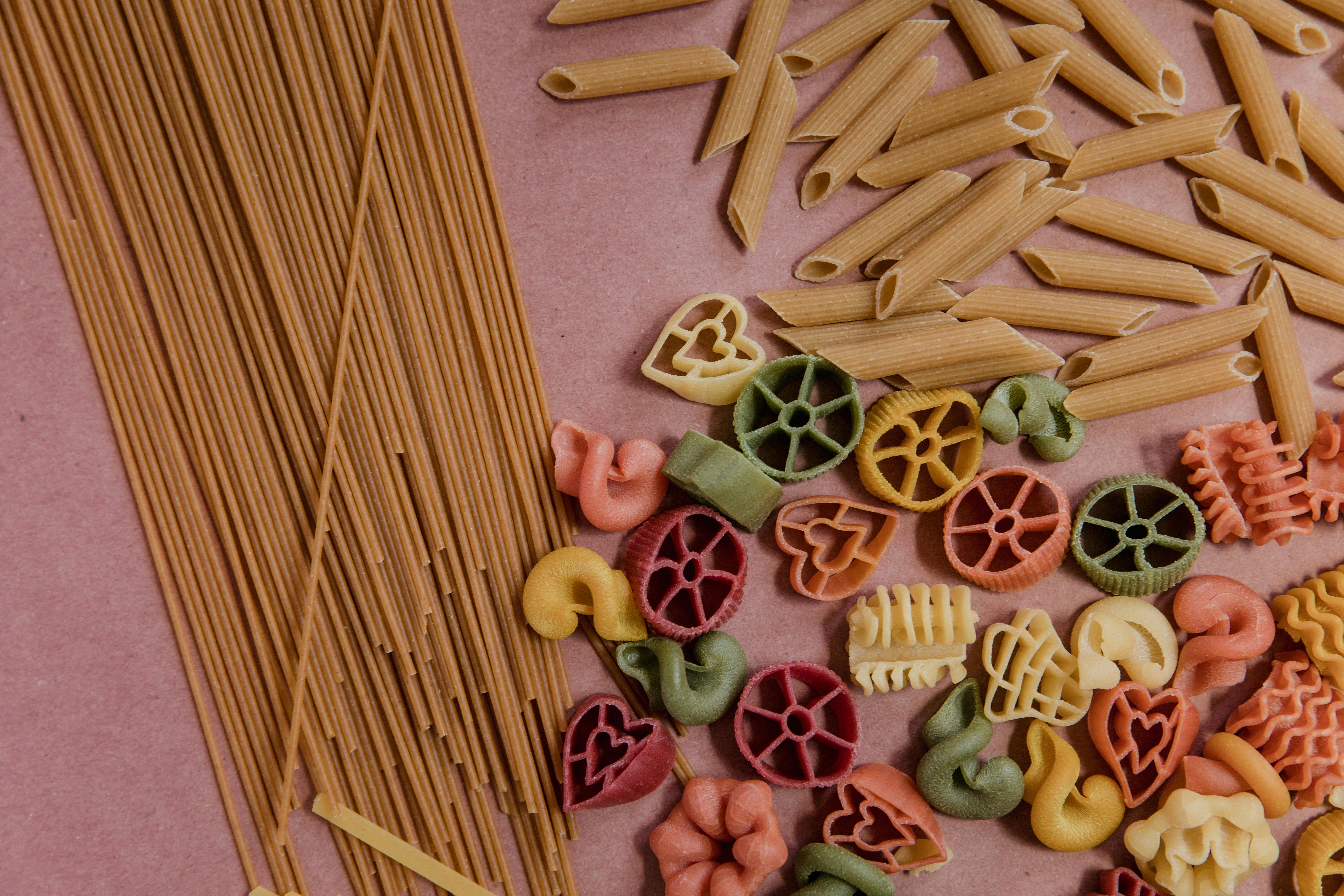 Assorted Uncooked Pasta on a Pink Surface · Free Stock Photo