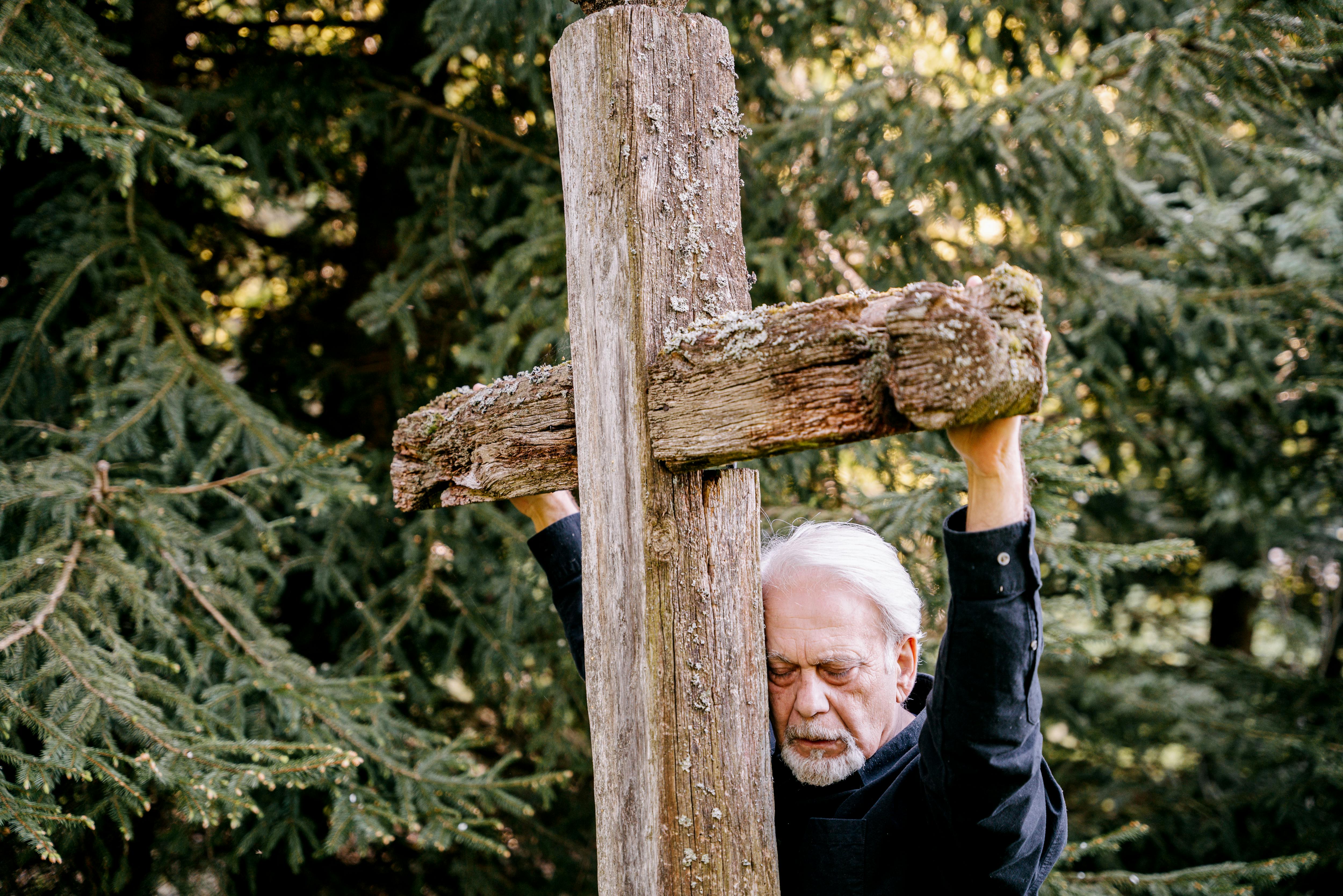 A Man Holding a Wooden Cross · Free Stock Photo