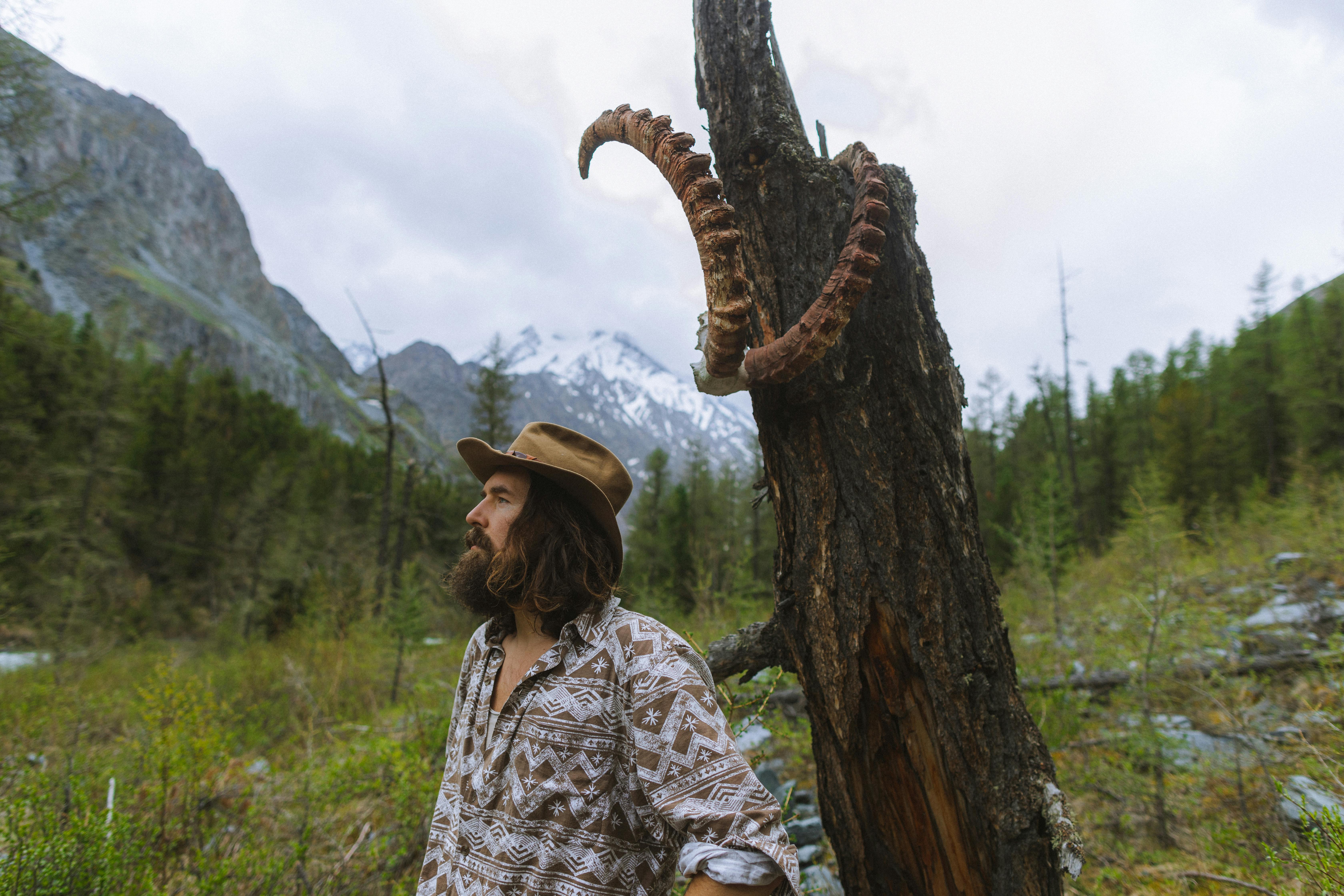 Man Standing Beside Tree Trunk · Free Stock Photo