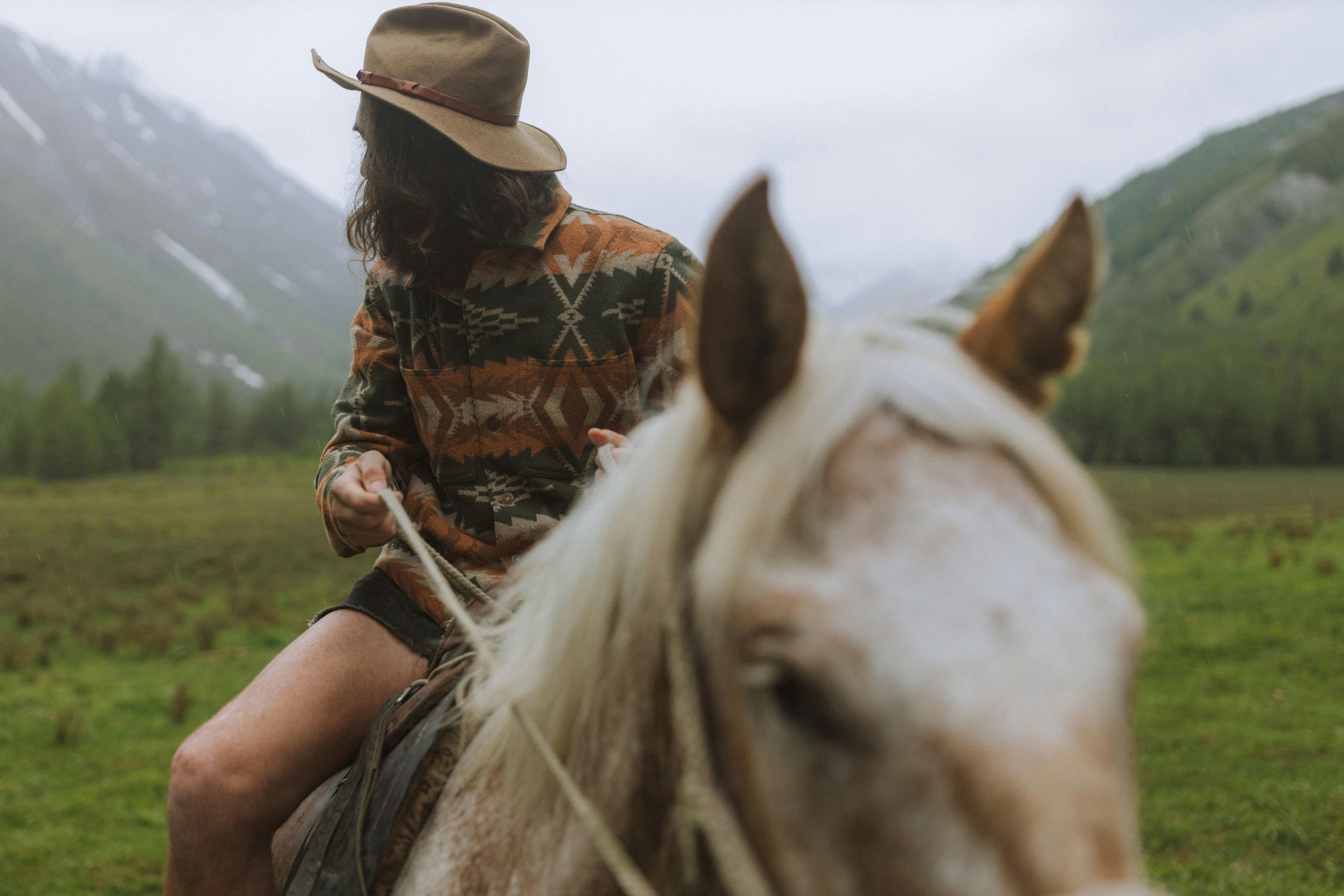 Brunette Man in a Beige Hat Riding a Horse in the Mountains · Free ...