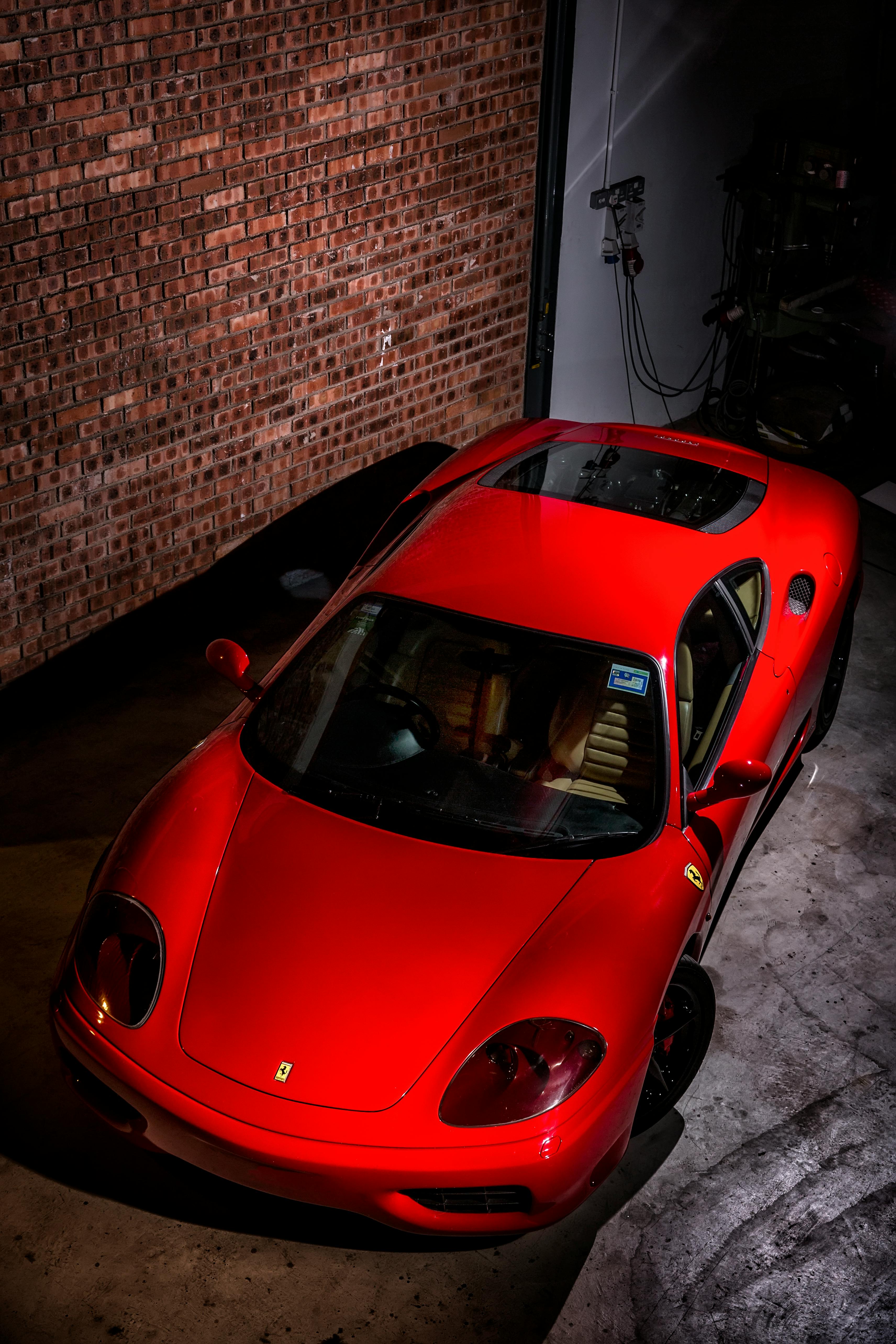 A Red Sports Car Parked inside the Garage · Free Stock Photo