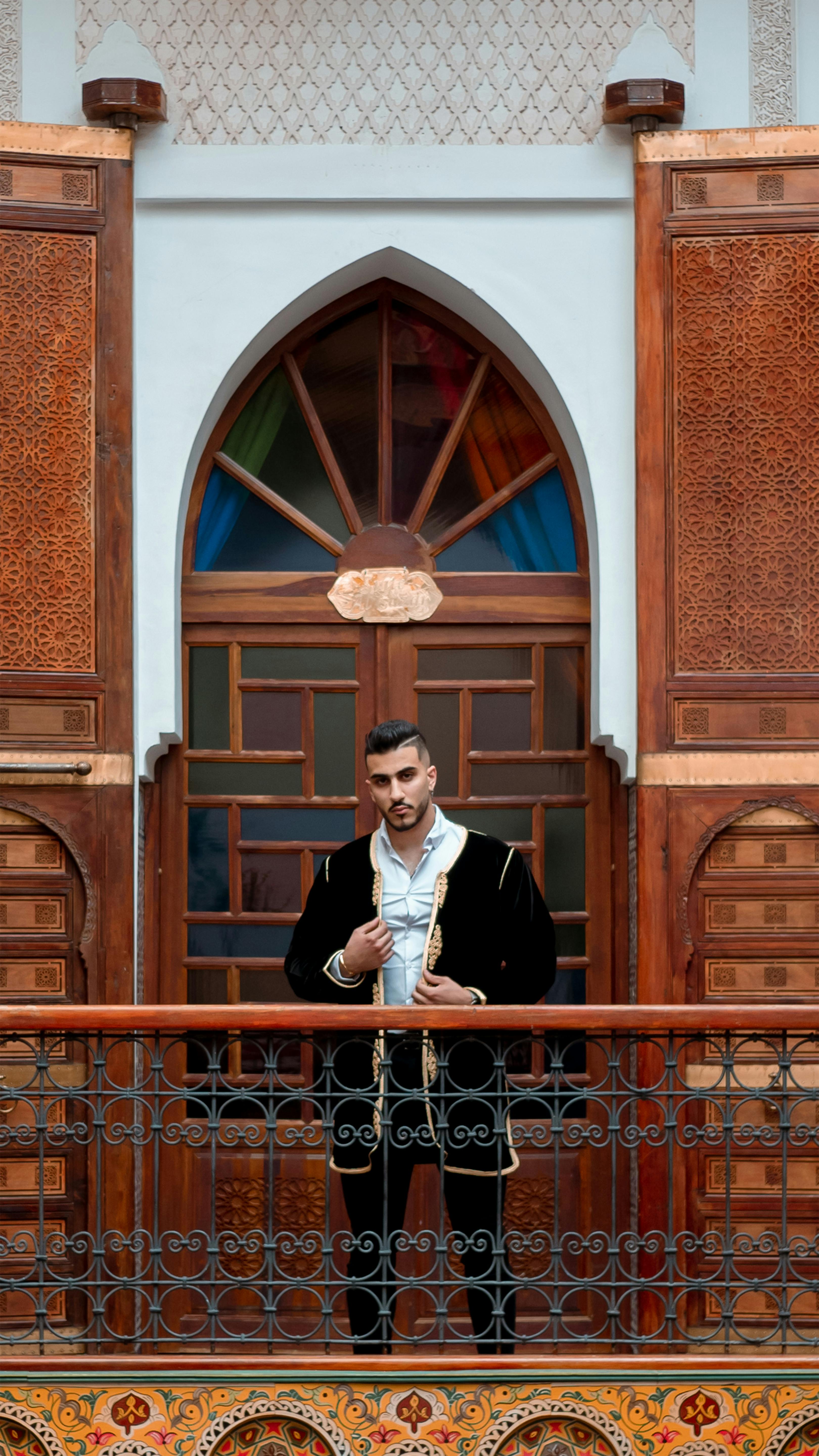 Man in Black Jacket Standing beside Brown and Black Railing · Free ...