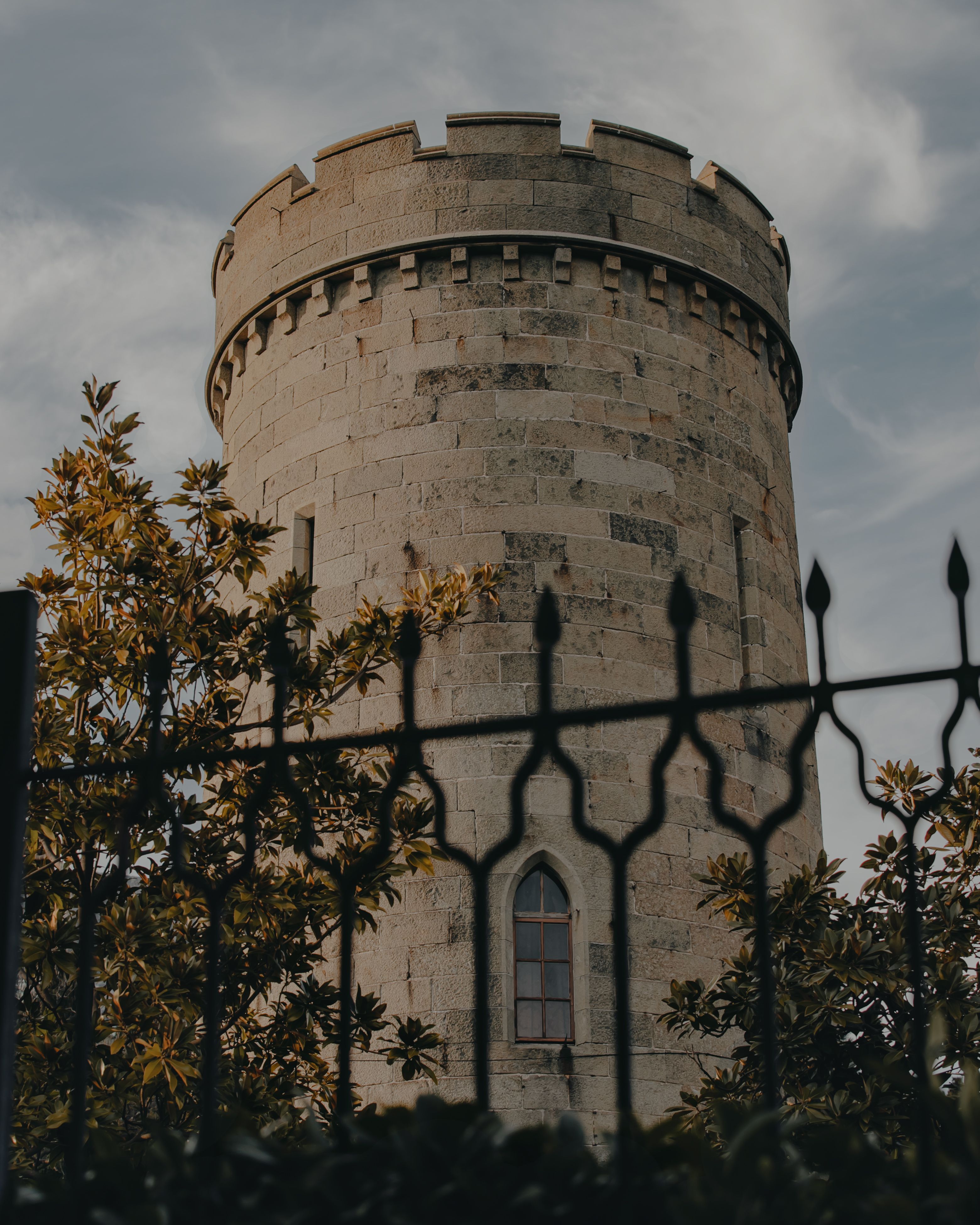 Cylindrical Brick Building Behind a Metal Fence · Free Stock Photo