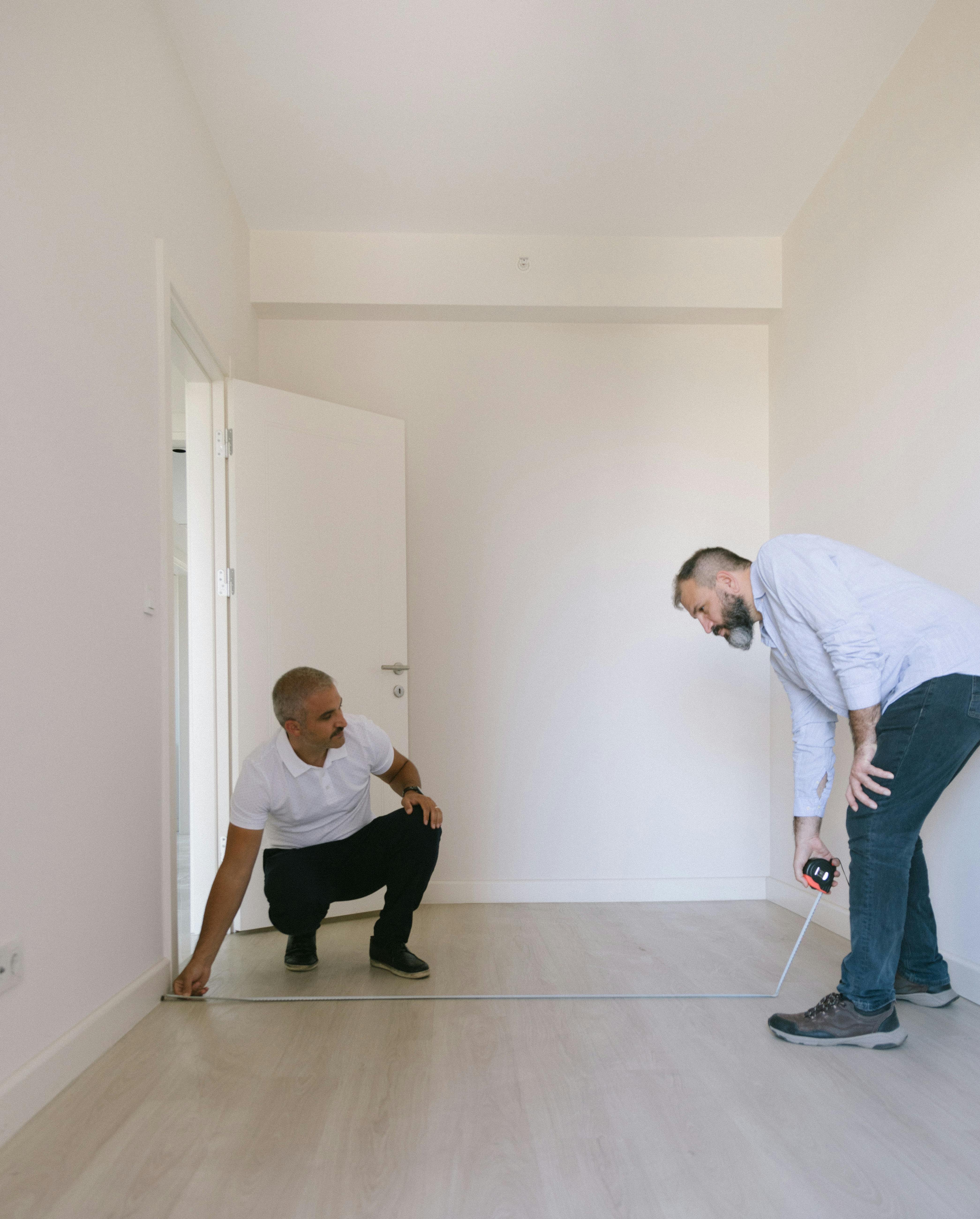 Men Measuring Floor of a Room · Free Stock Photo