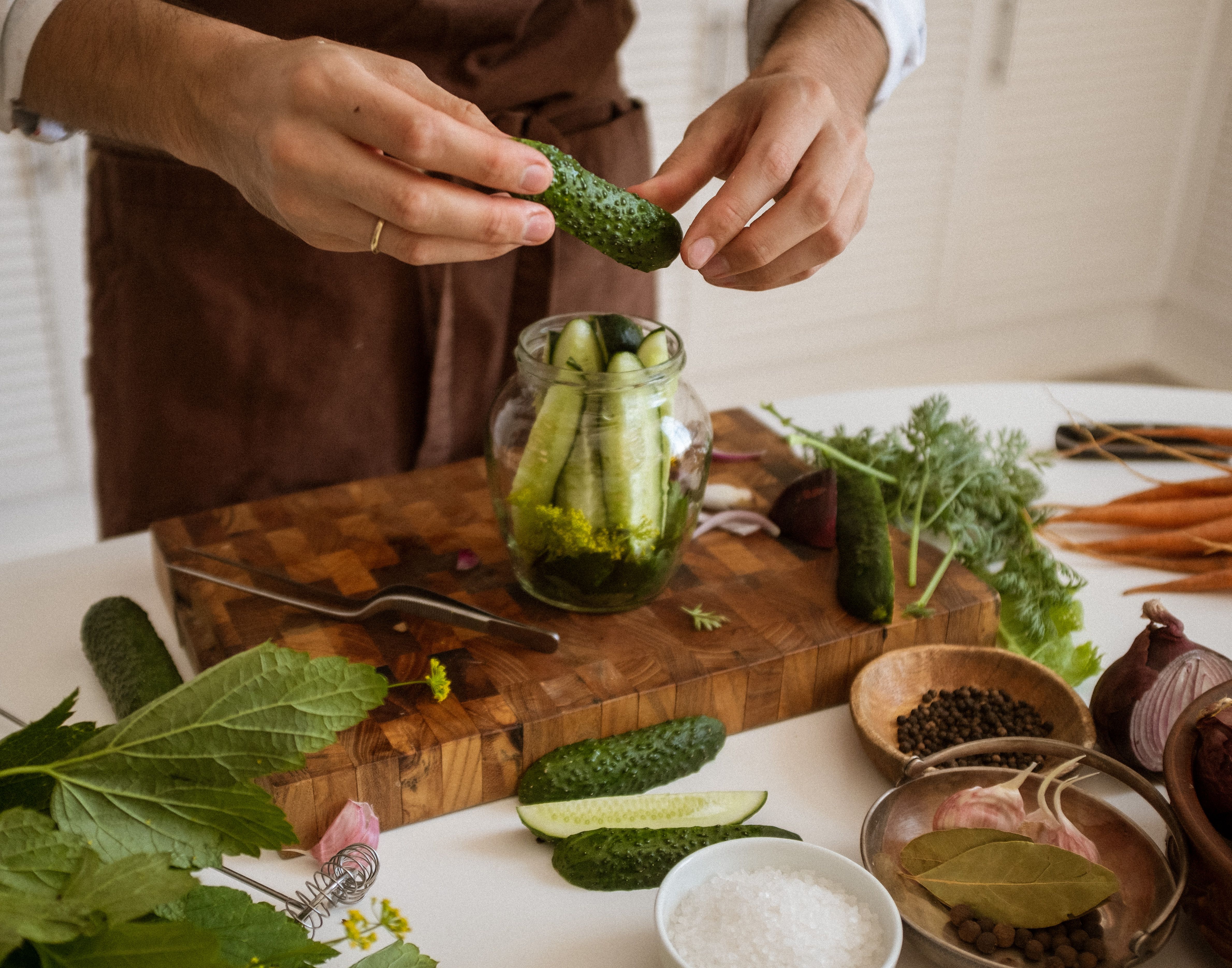 A Person Putting Sliced Cucumbers in a Jar · Free Stock Photo
